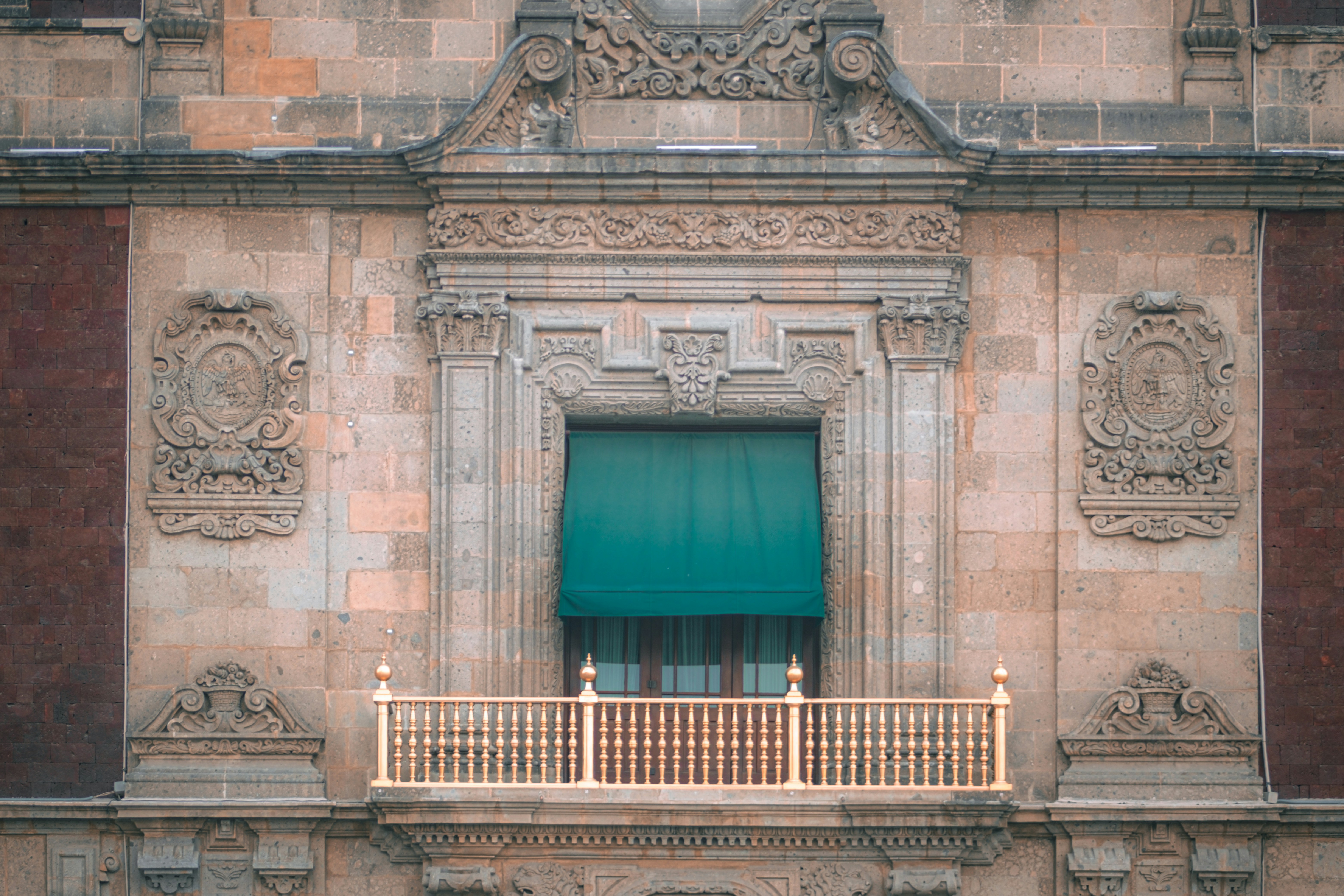 Towering Facade: Green Canopy Over Ornate Balcony