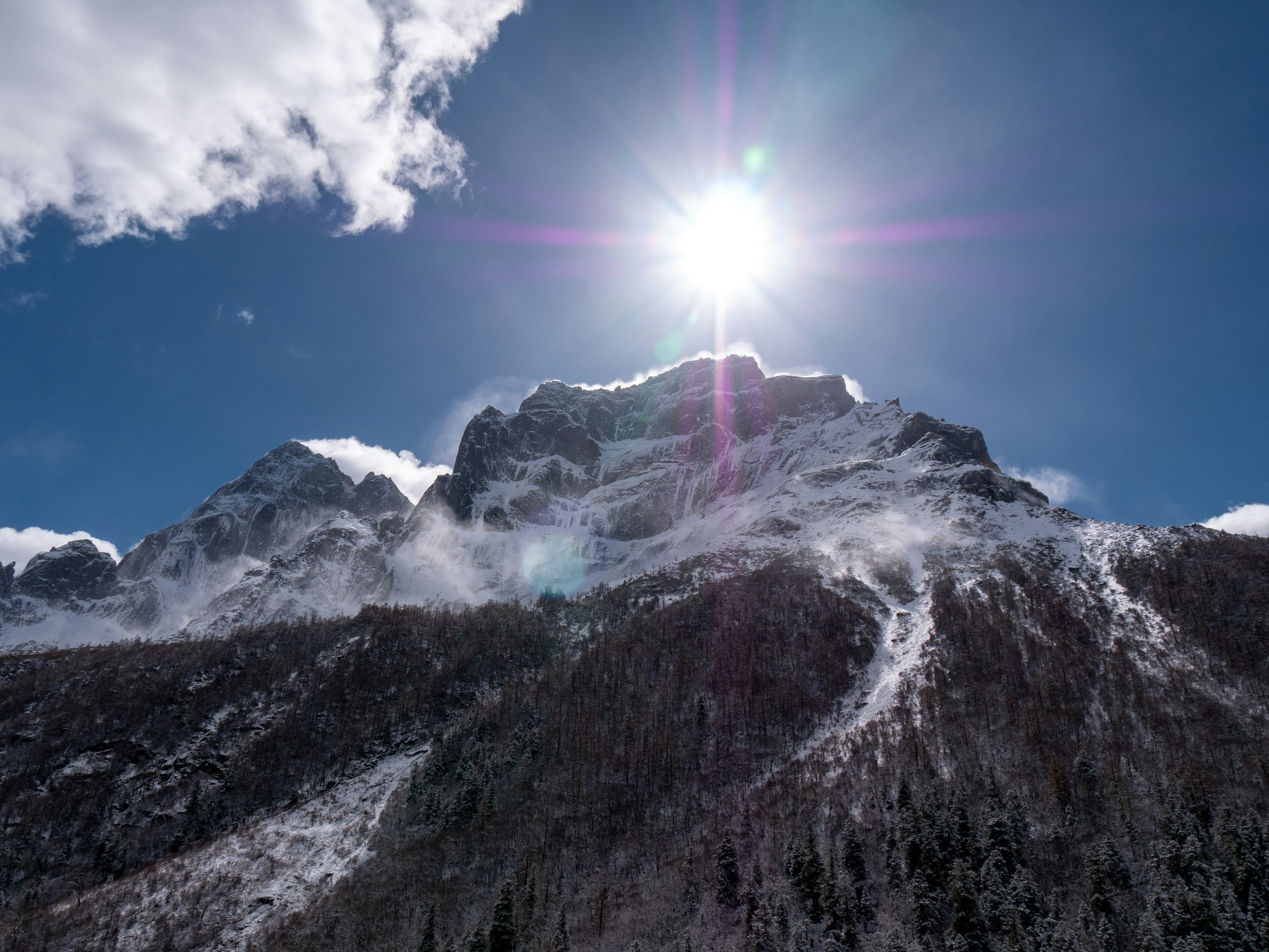 Sunlit Summit: A Frozen Crest Under a Blue Winter Sky