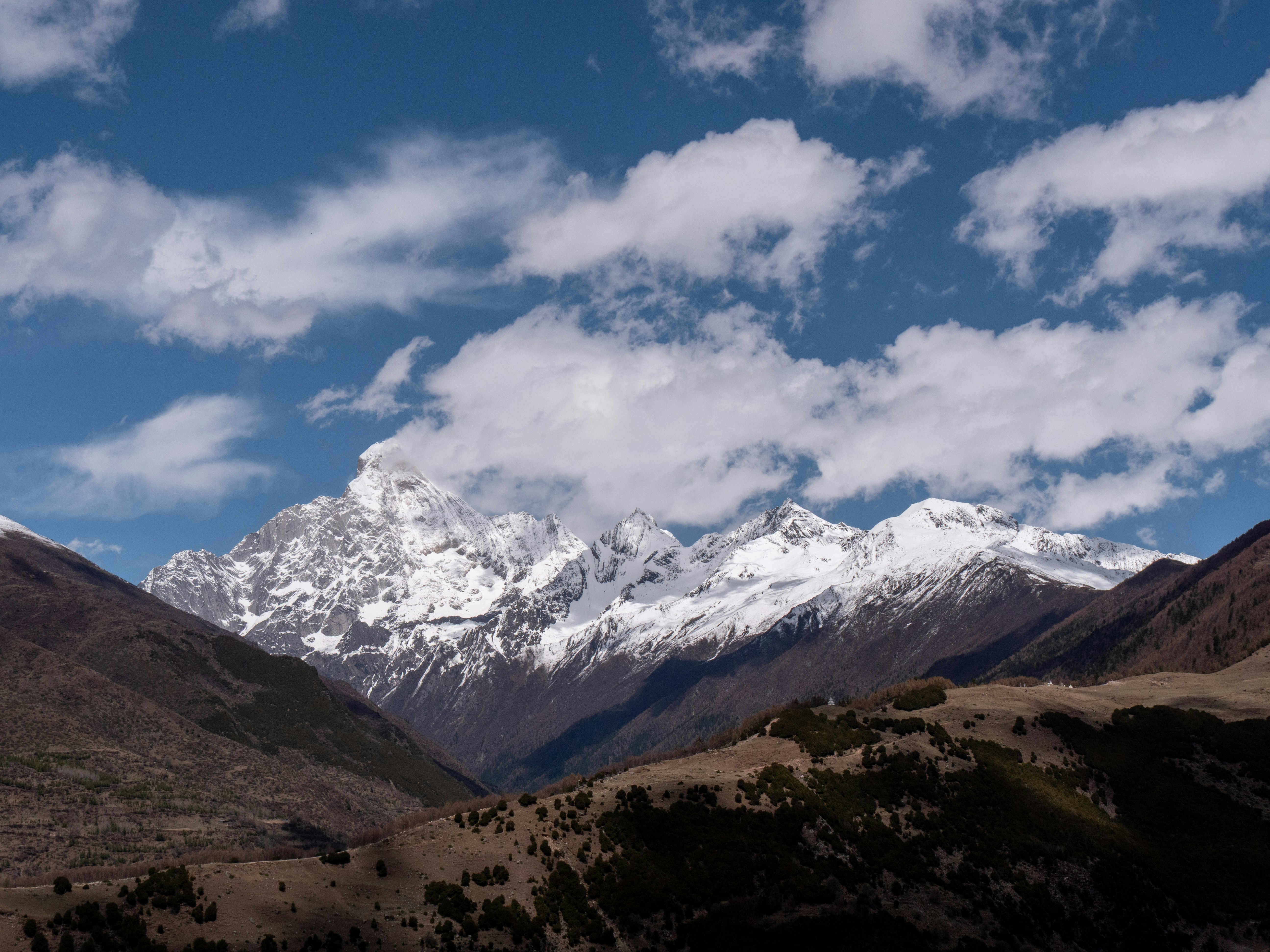 Snow-Capped Peaks Framed by rolling foothills under a bright alpine sky