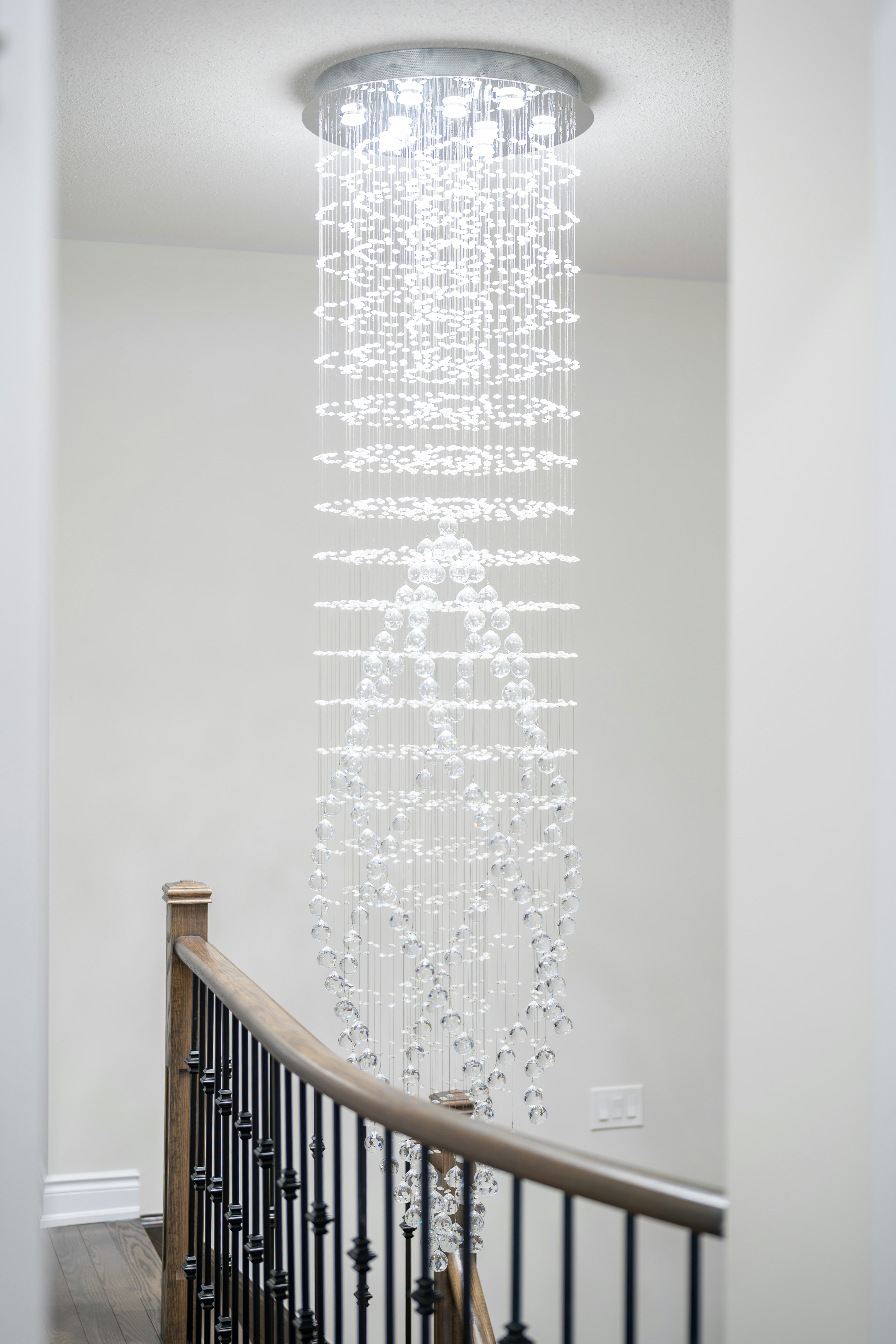 Chandelier Mist: Crystal Threads Descend Over a Wrought-Rail Staircase