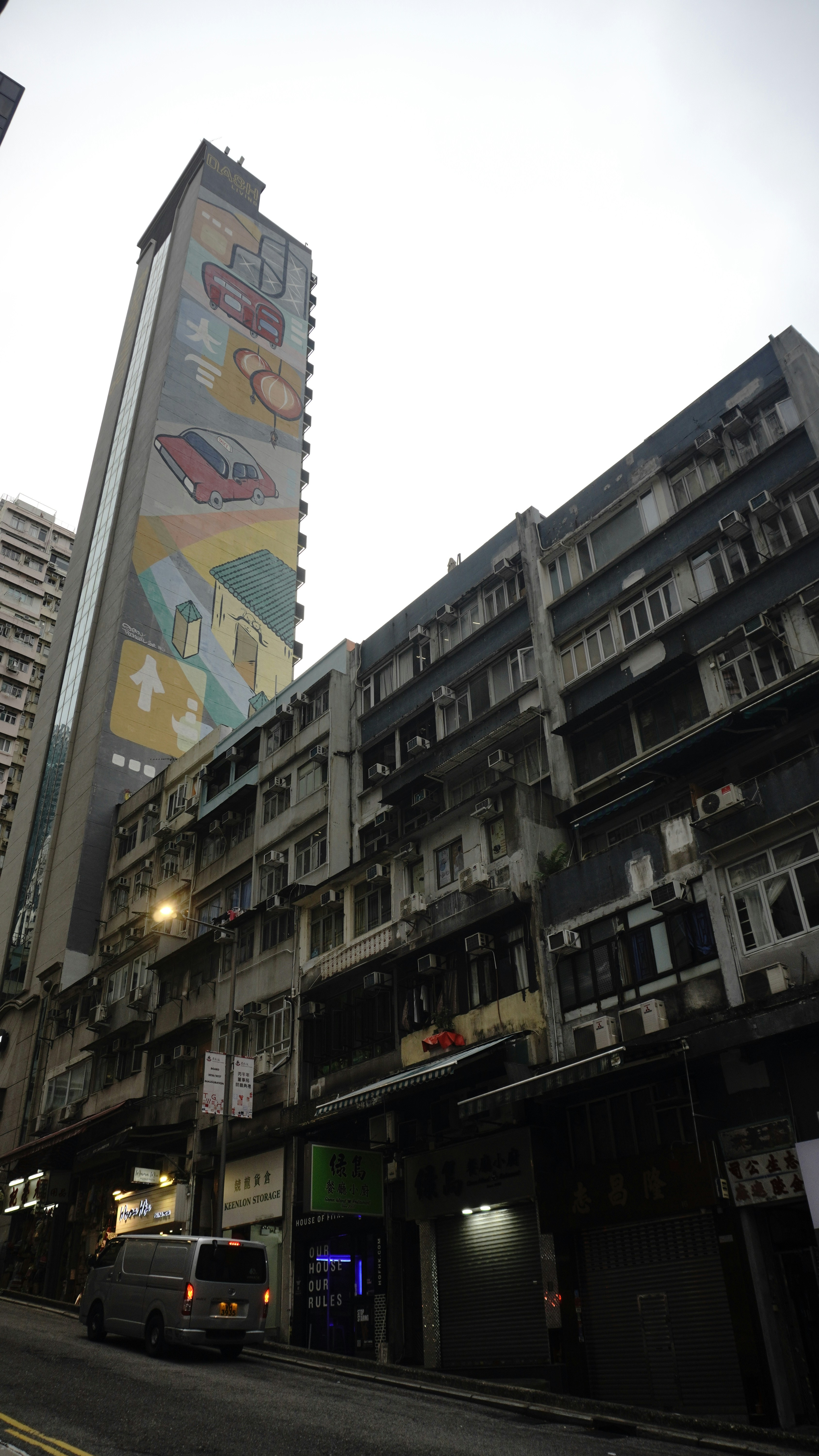 Urban mural towers over a weathered street scene