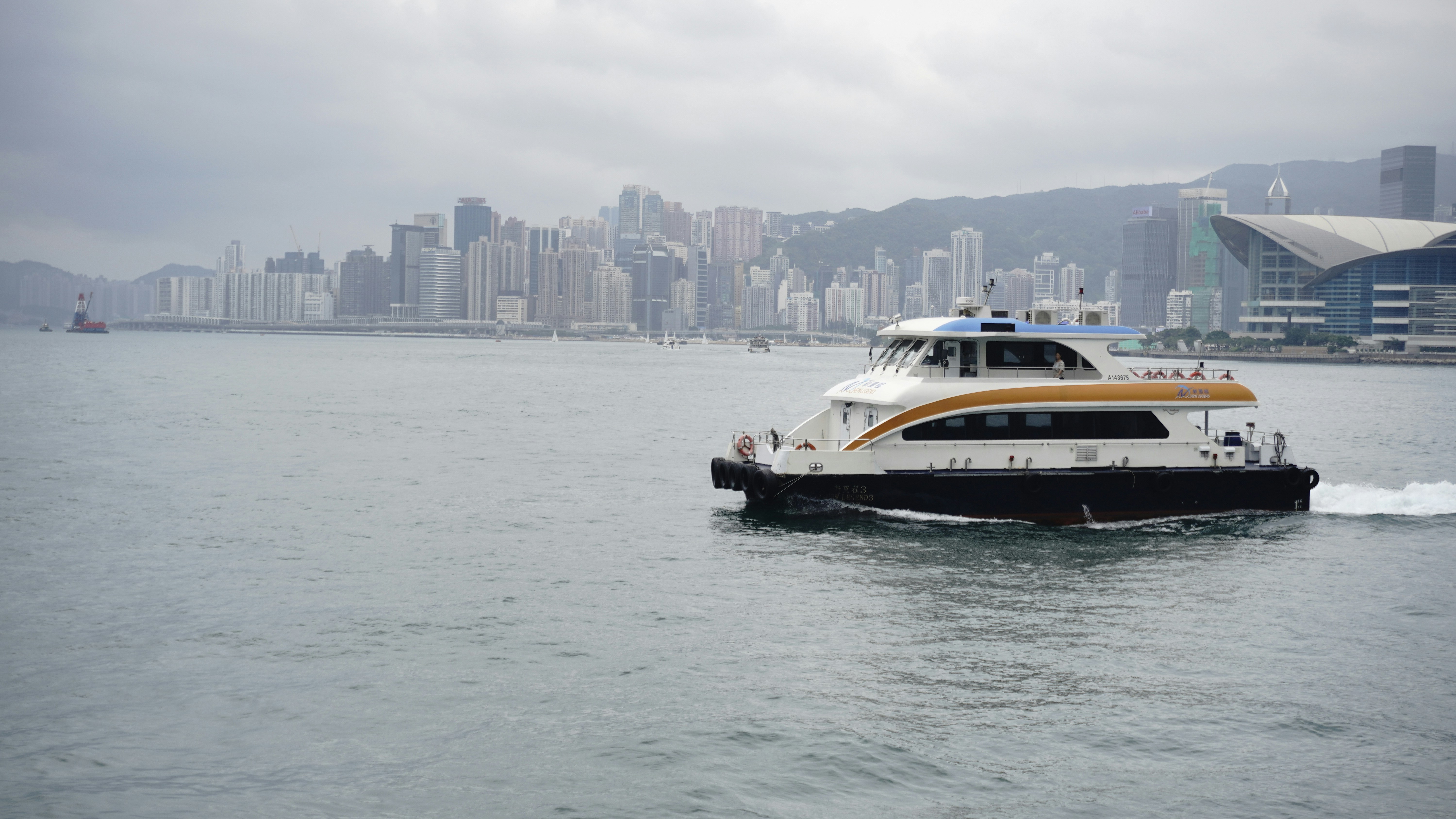 Luxe ferry gliding past Hong Kong’s skyline at sea
