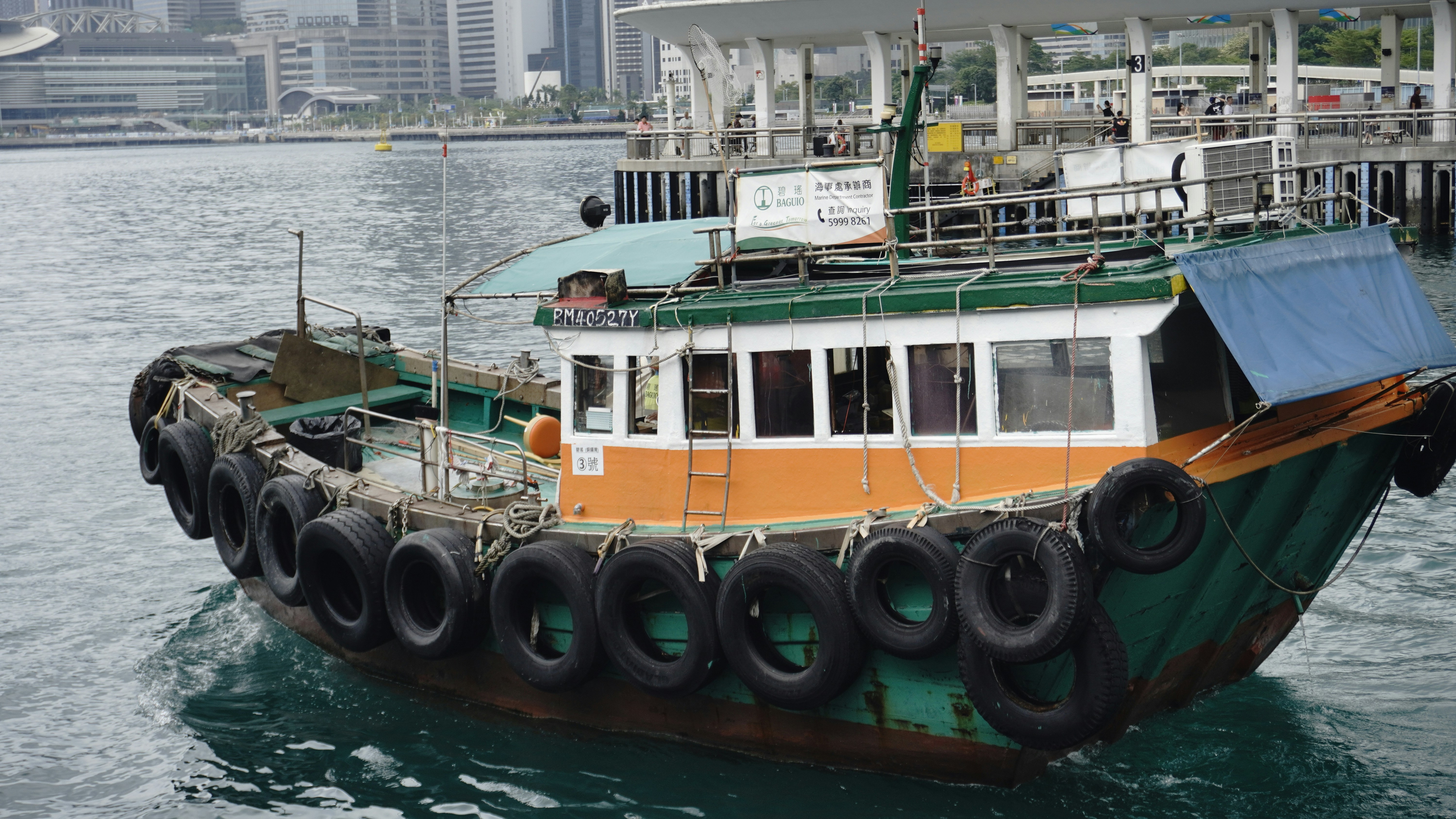 Tugboat Docked Along the Waterfront Tire Ringed by Floats