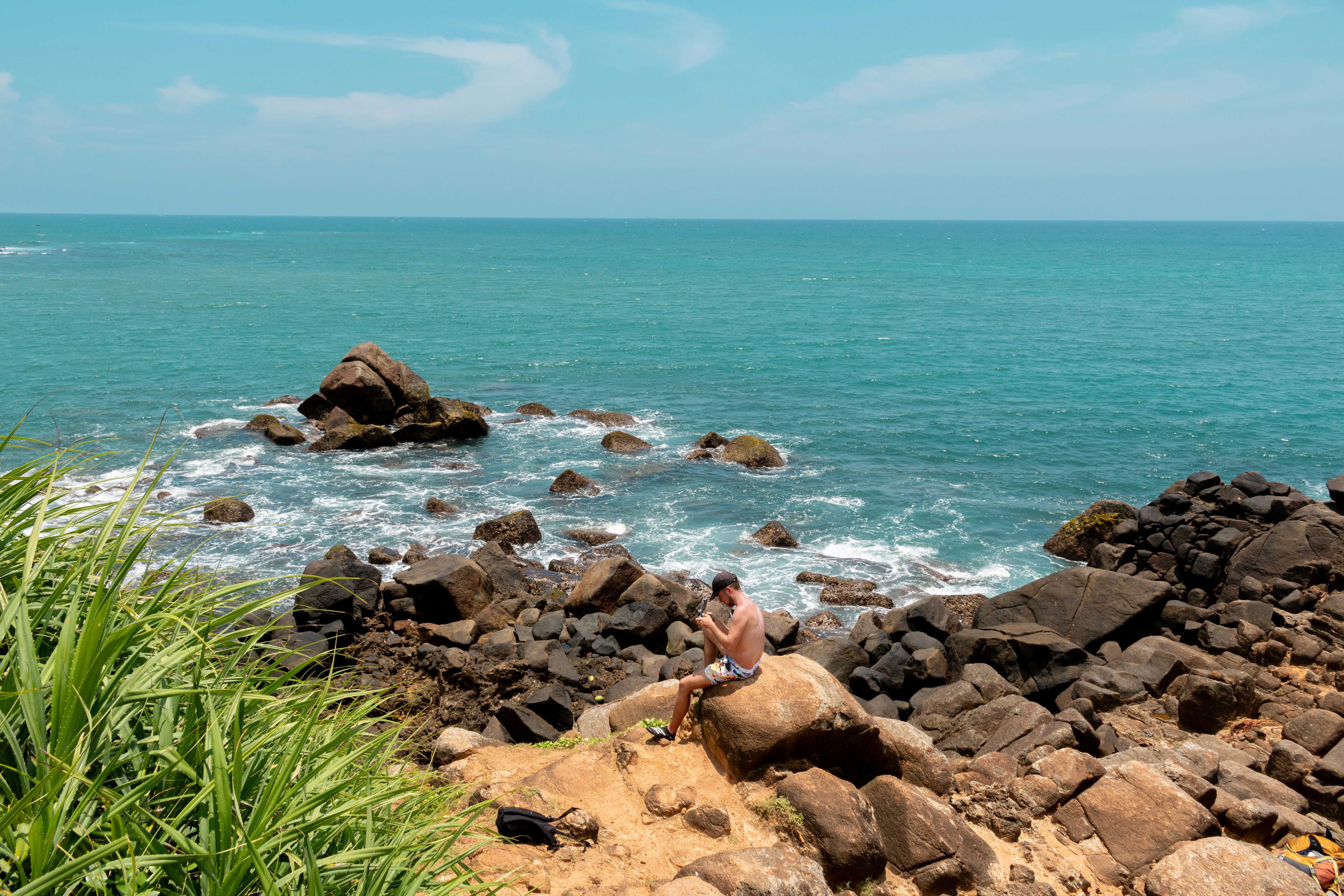 Rocky Cove: A Lone Figure Amidst Turquoise Waves