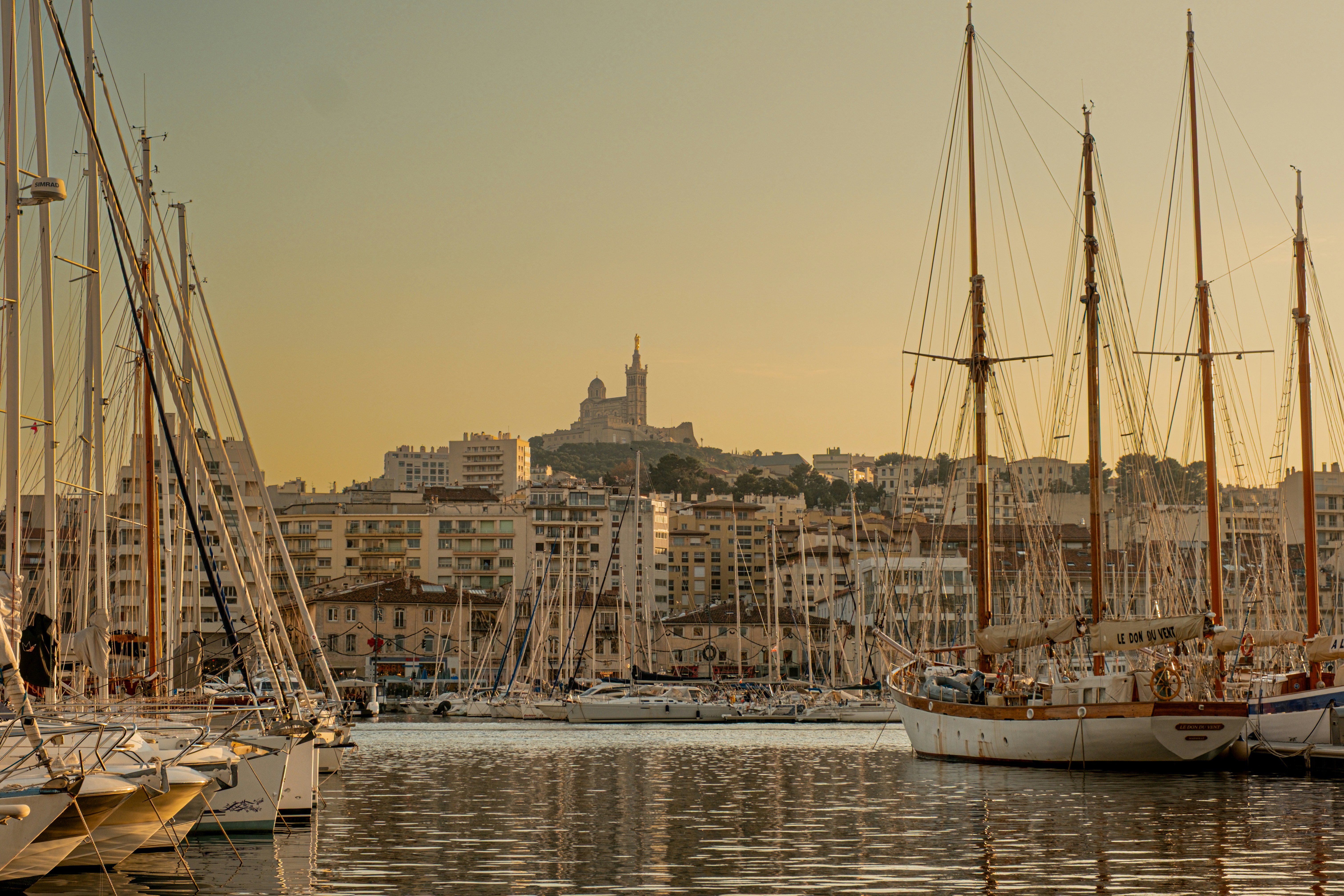Harbor in Golden Haze: Boats and a distant hillside citadel