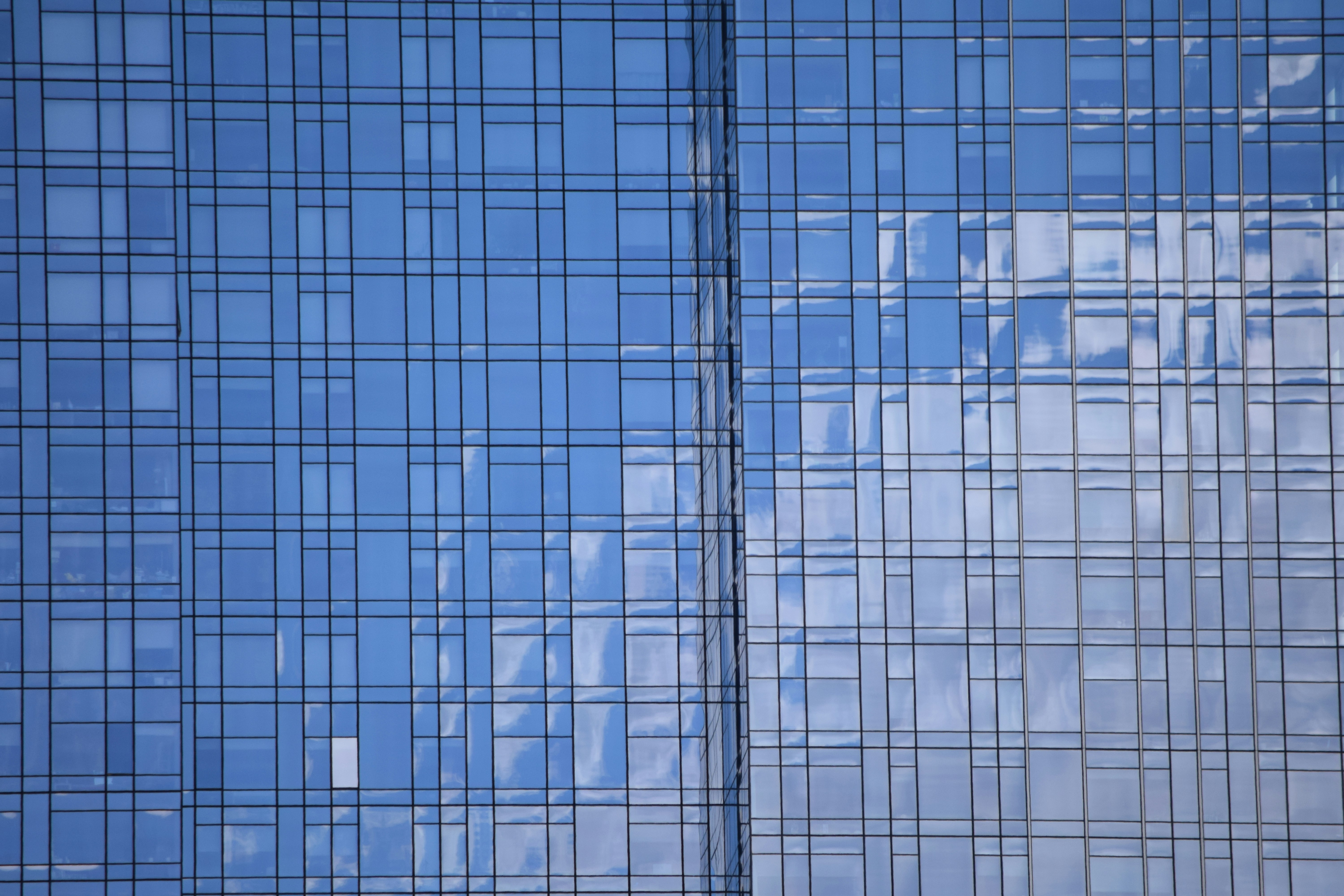 Grid Reflections: A Glass-Fan Window Fractures into Sky