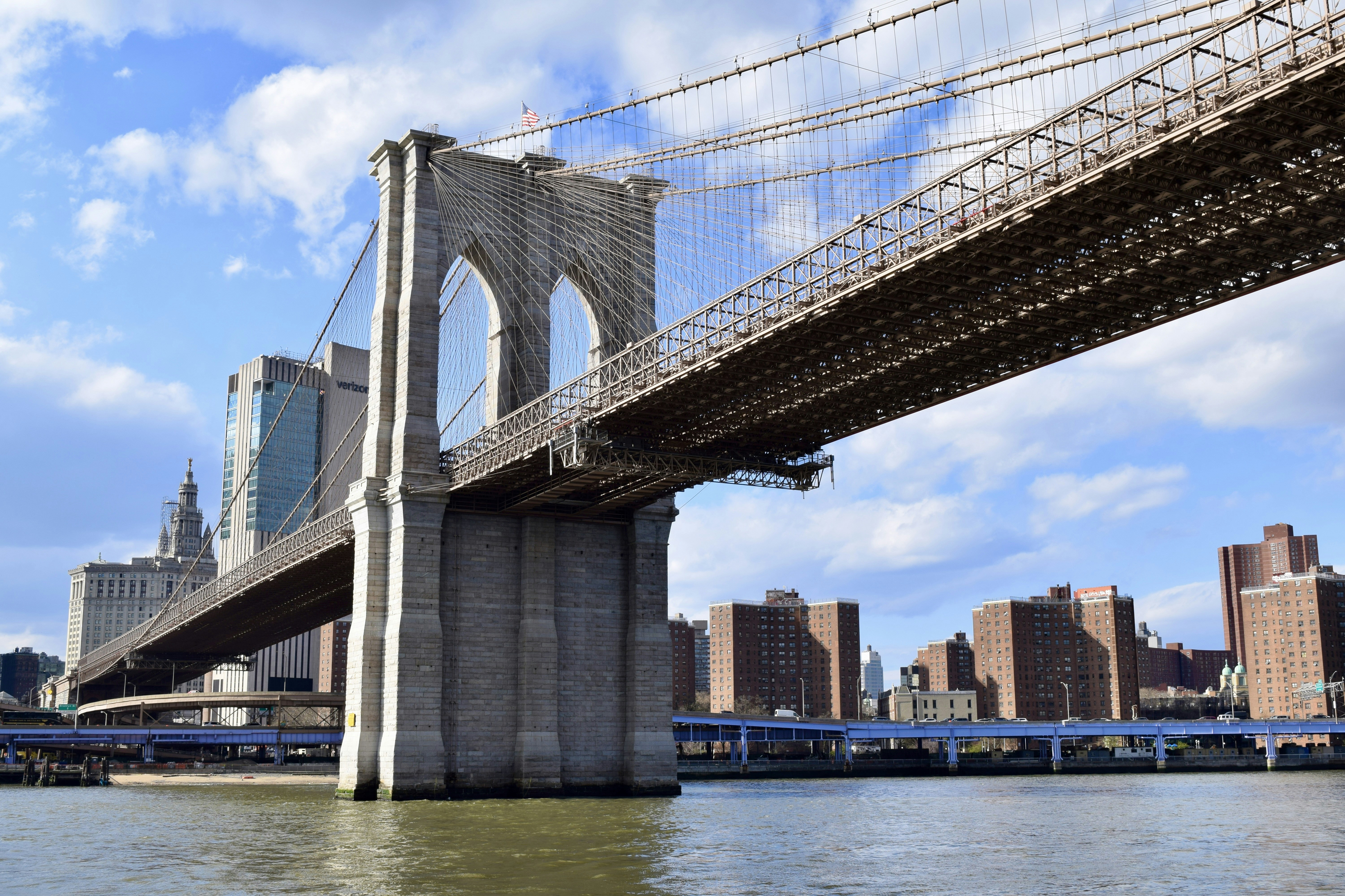 Under the Arch: A Sunlit Vista of the Brooklyn Bridge and City Skyline