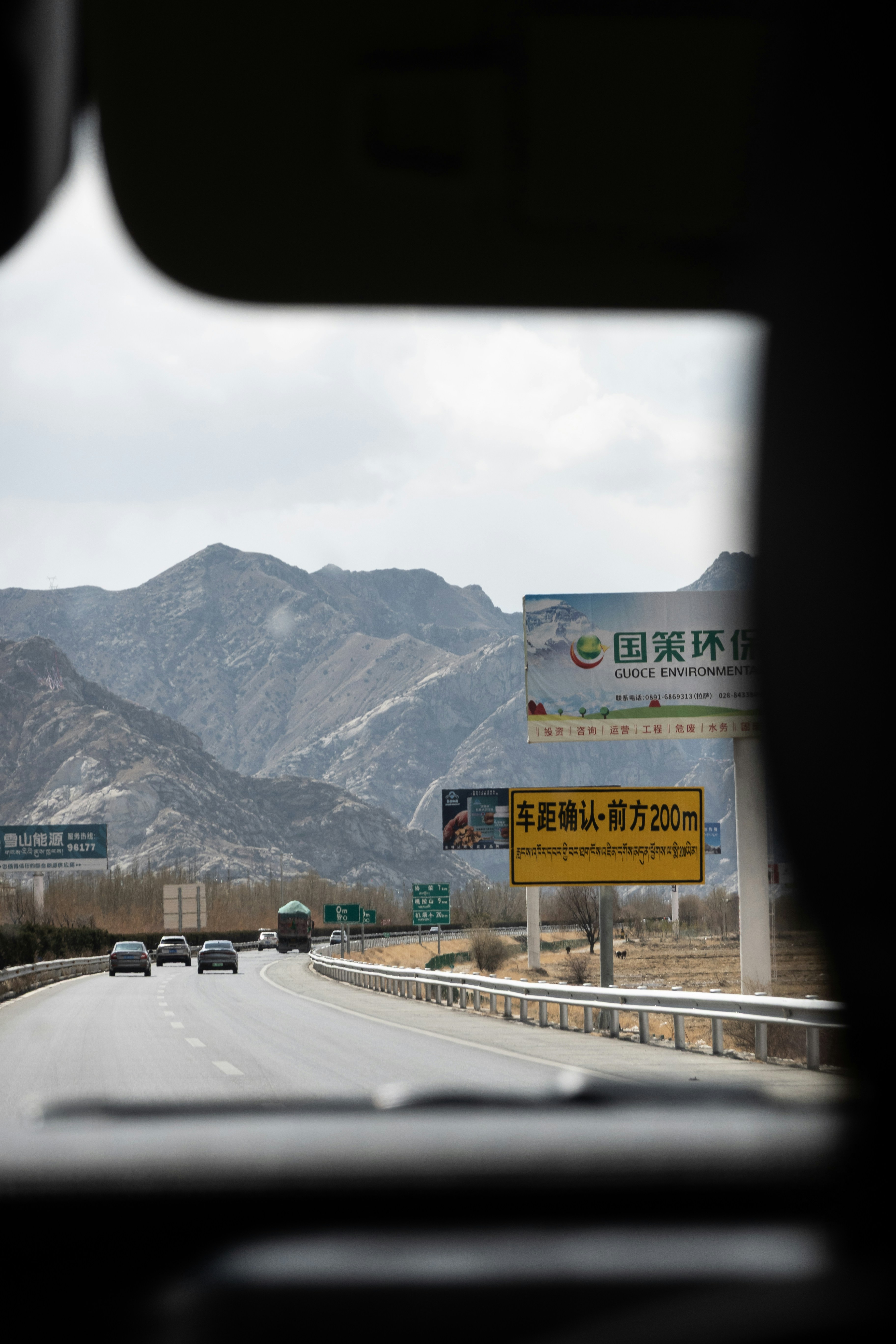 Highway Through the Foothills: Road Signs Framing a Mountain Pass