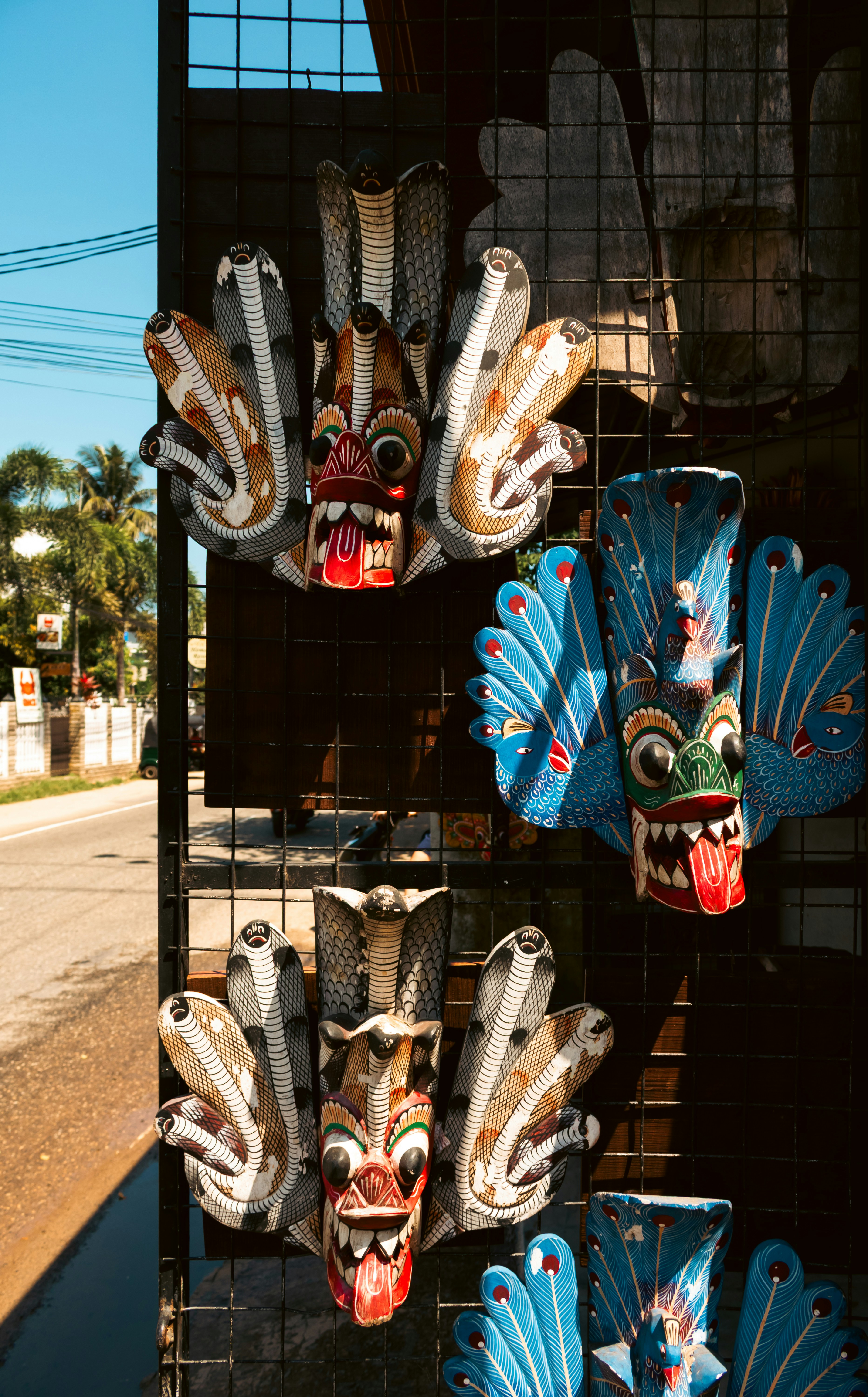Colorful Ceramic Masks on a Grid Wall: A Shopfront of Carved Expressions