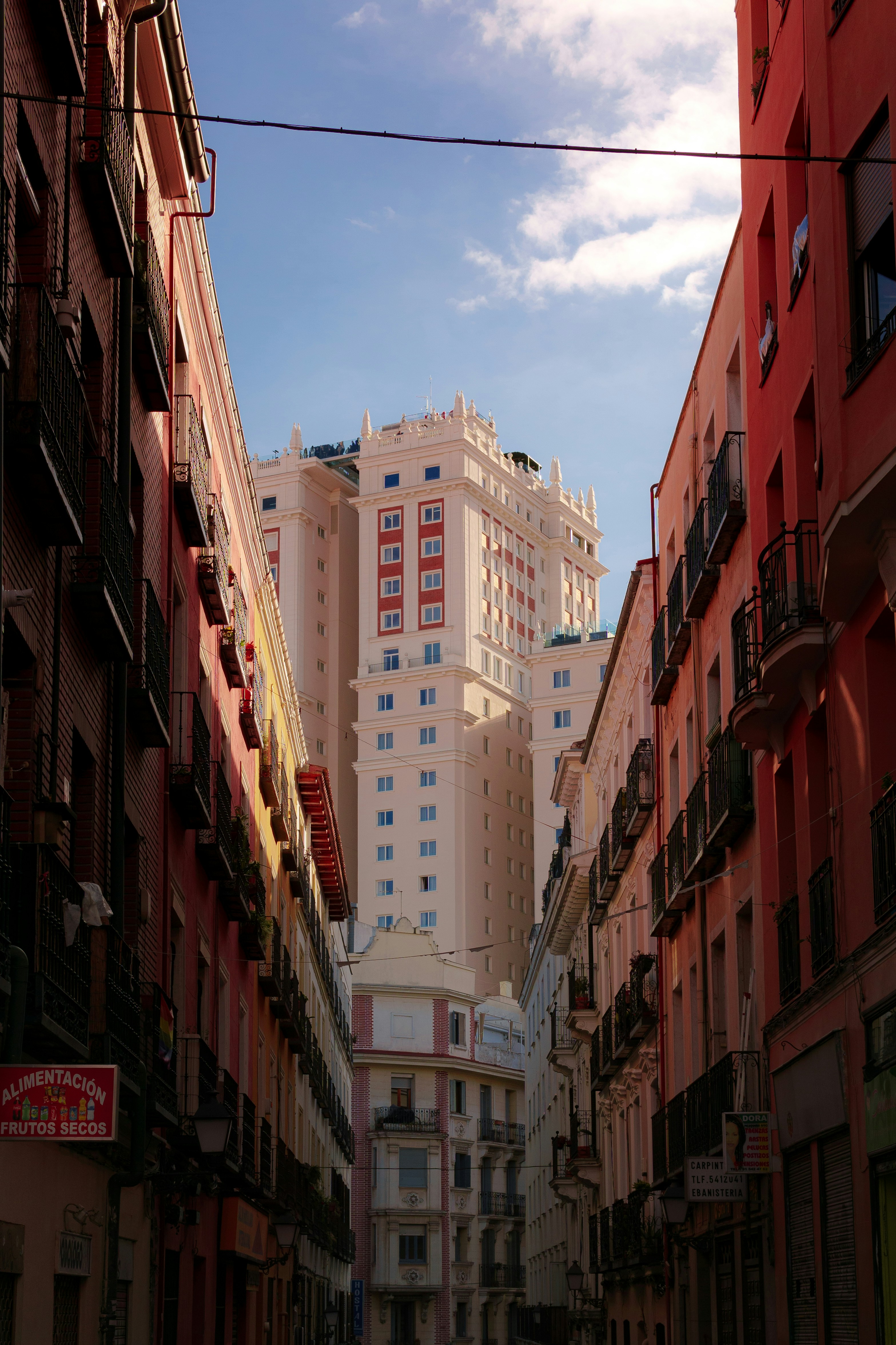 Chroma Corridor: Sunlit Sky Over an Andaluz Tower Amid Narrow Urban Gables