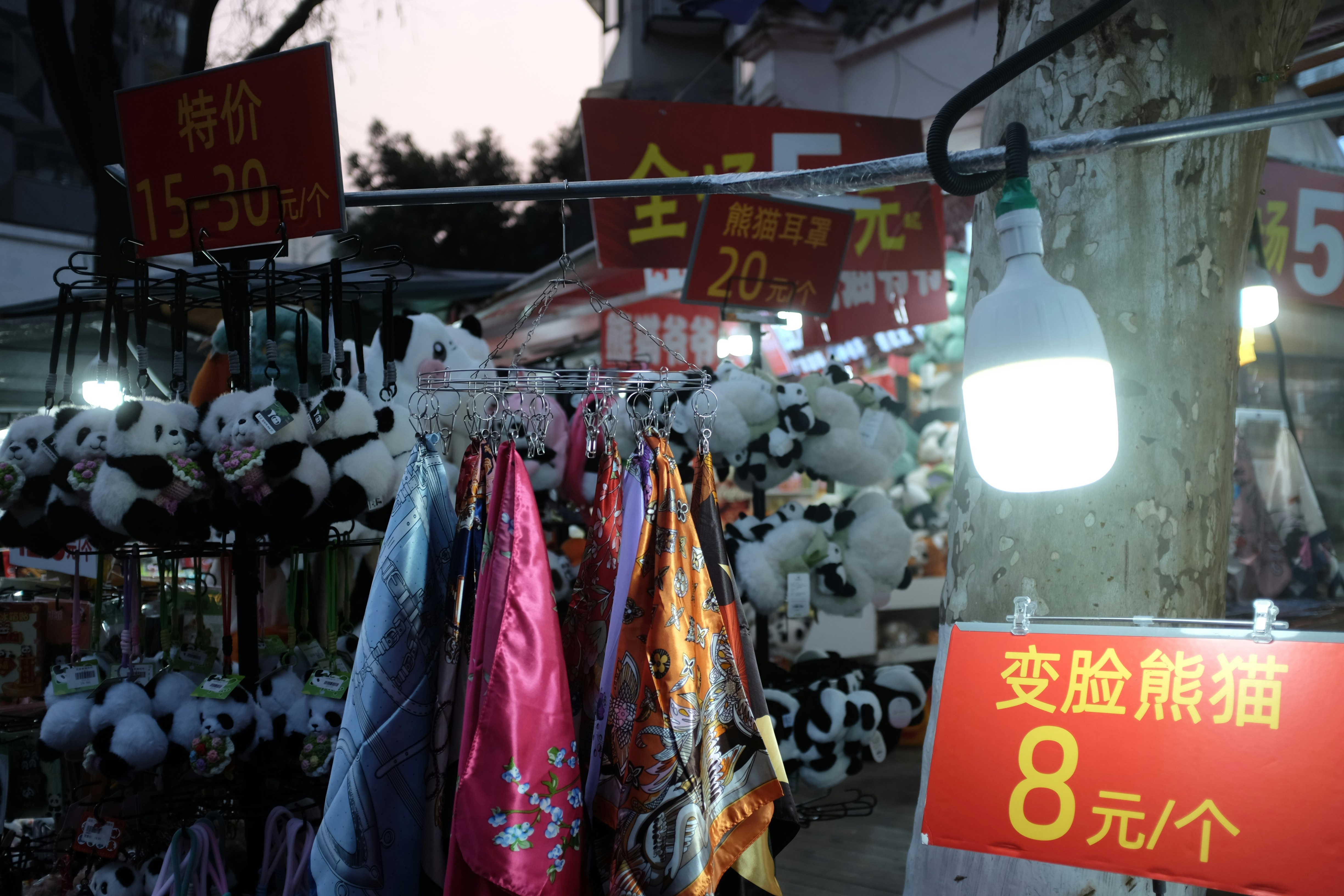 Evening Market Glow: Plush Toys and Signs Under Neon Light