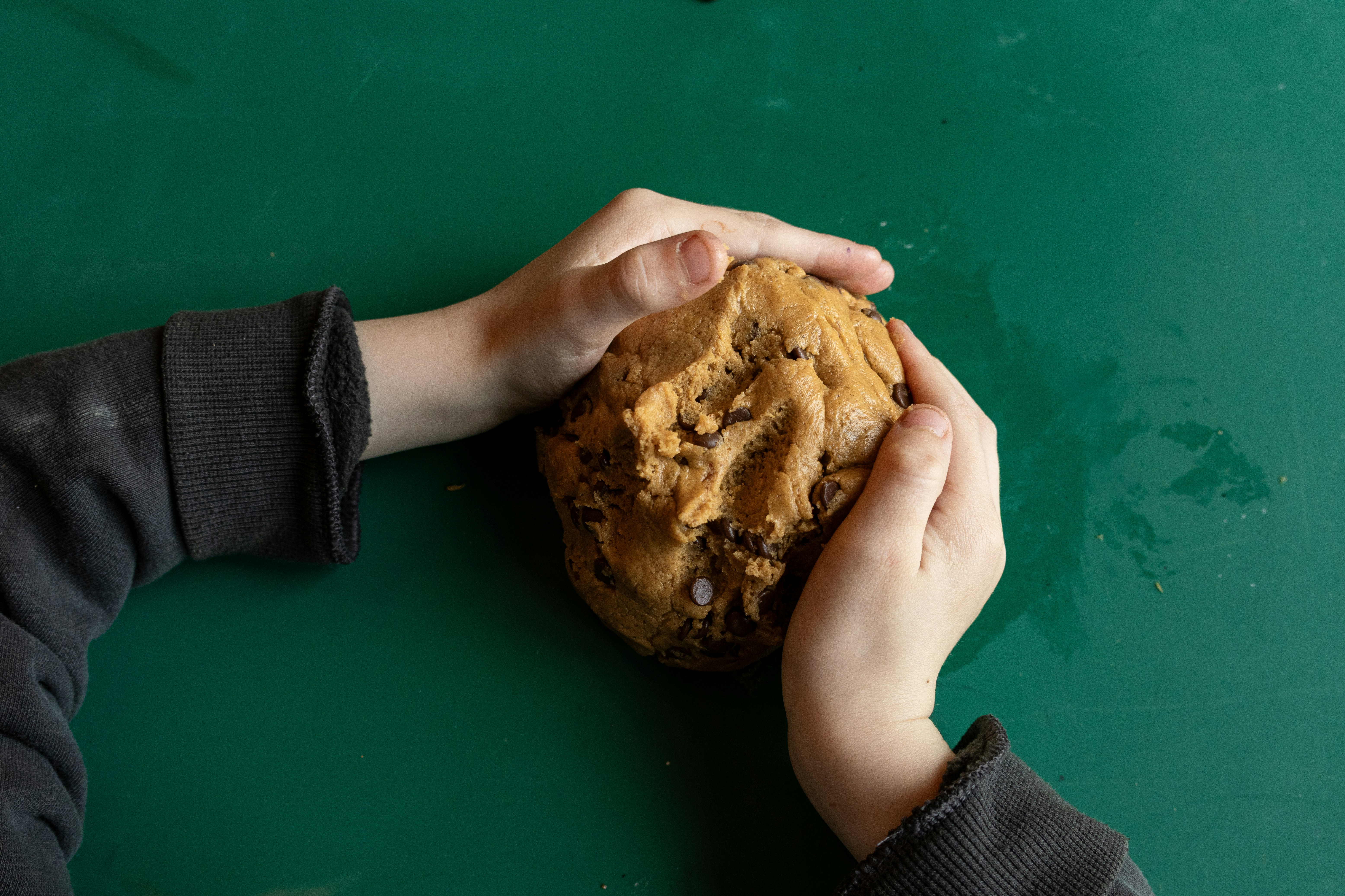 Hands and cookie: a quiet moment of focus over a crumbling treat