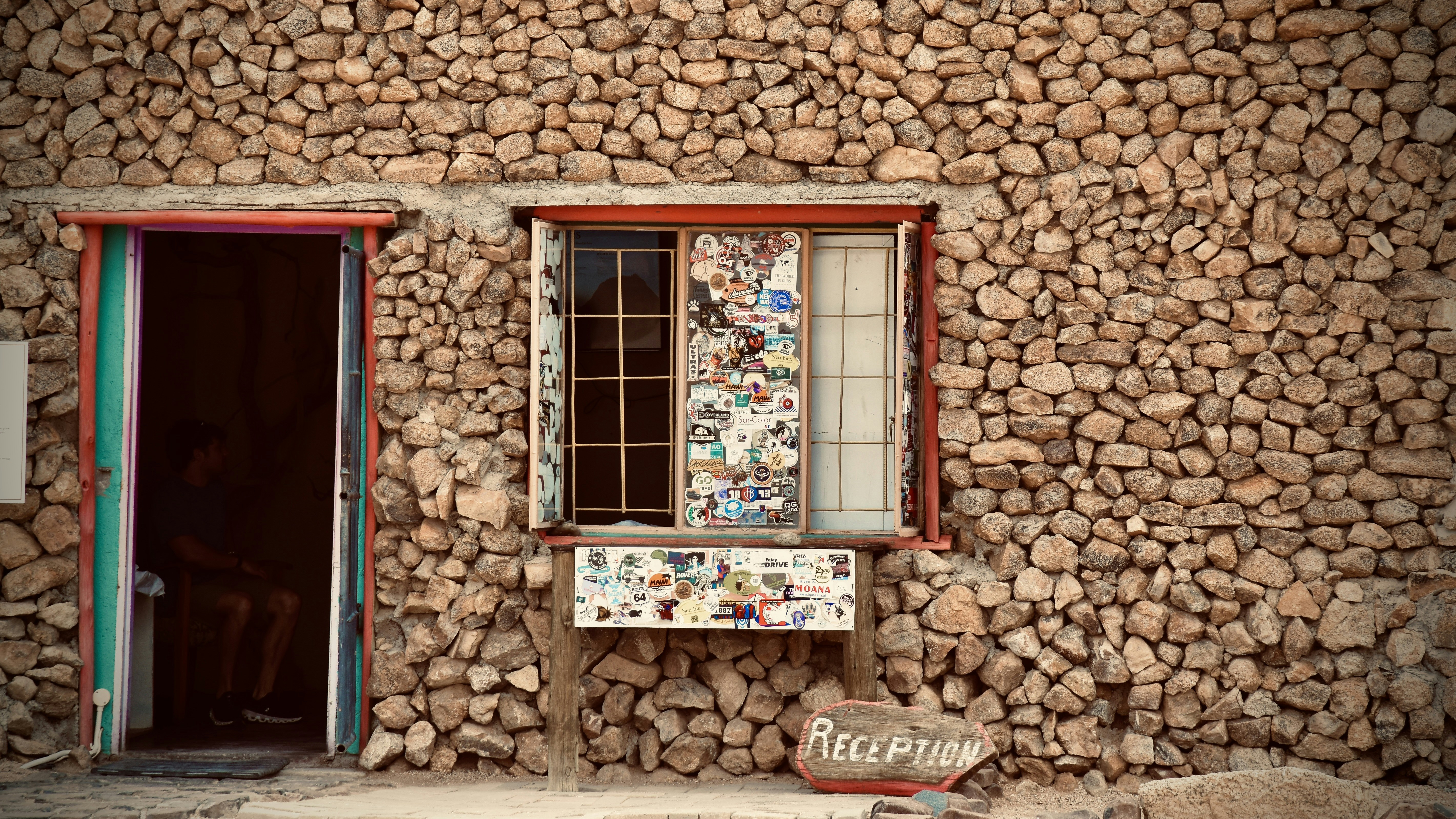 Stonemason’s Doorway: A Cracked Facade and Stickered Window