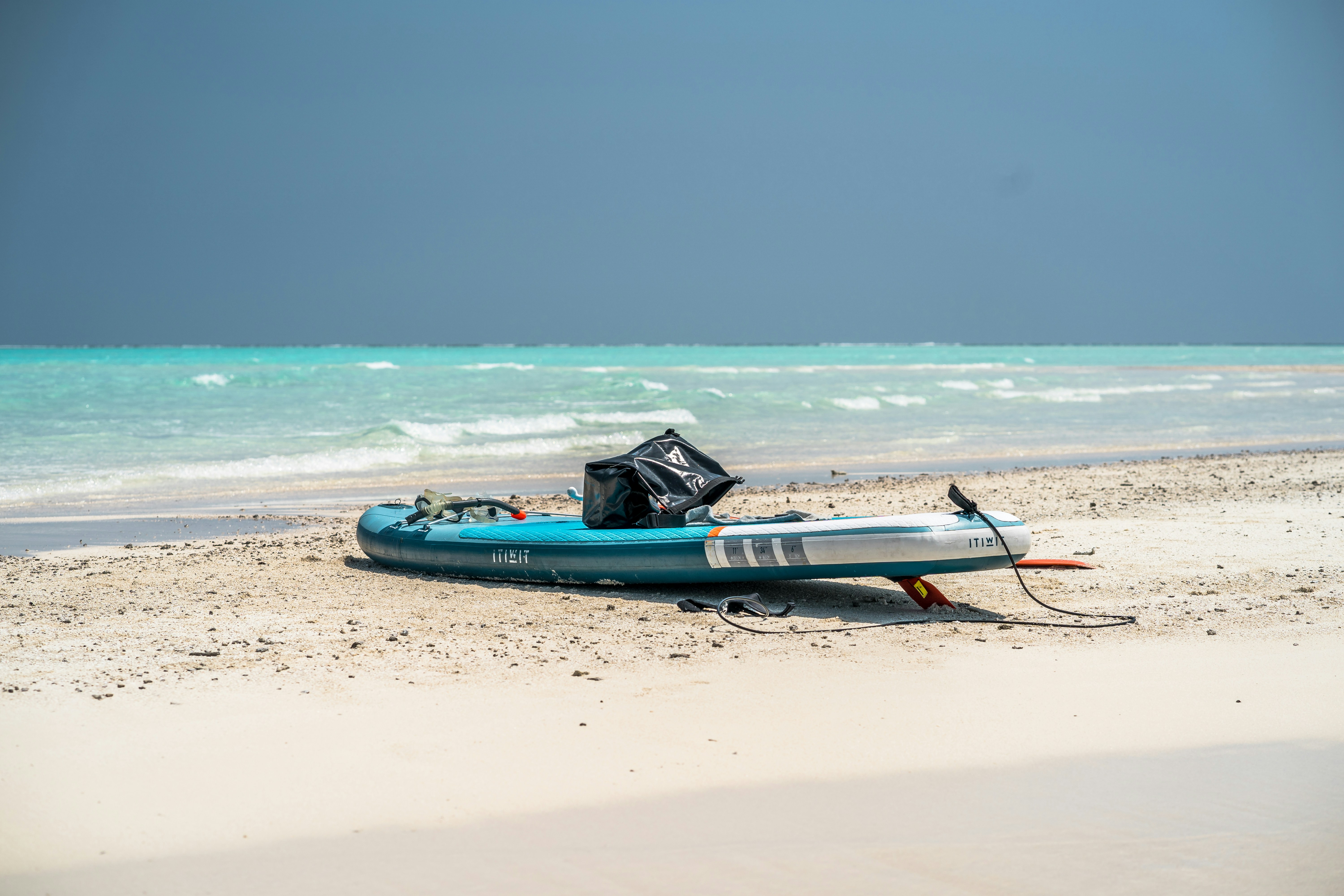  lifeboat resting on sunlit beach with turquoise sea