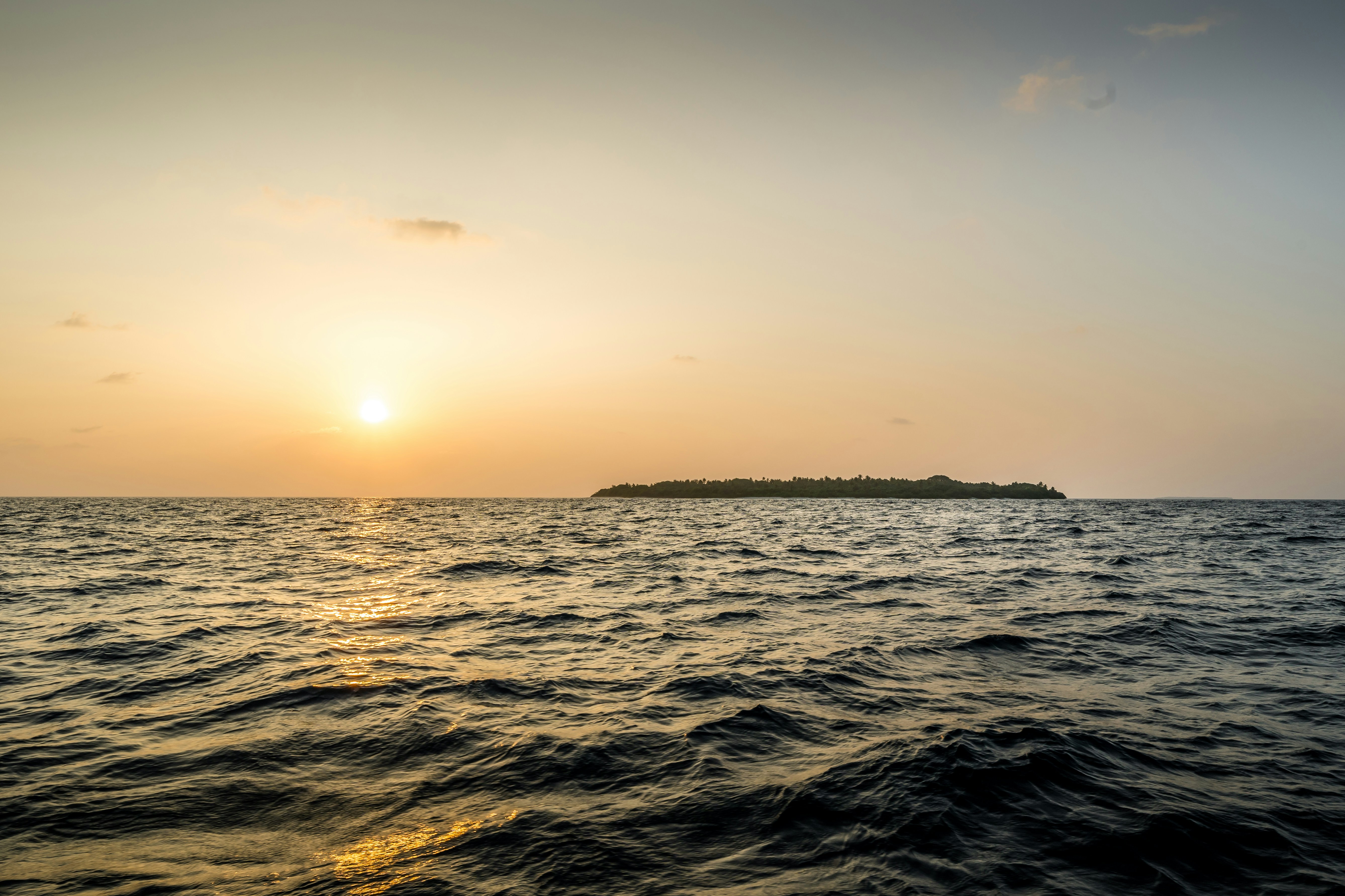 Sunset Over a Quiet Sea: An Island Dims the Horizon