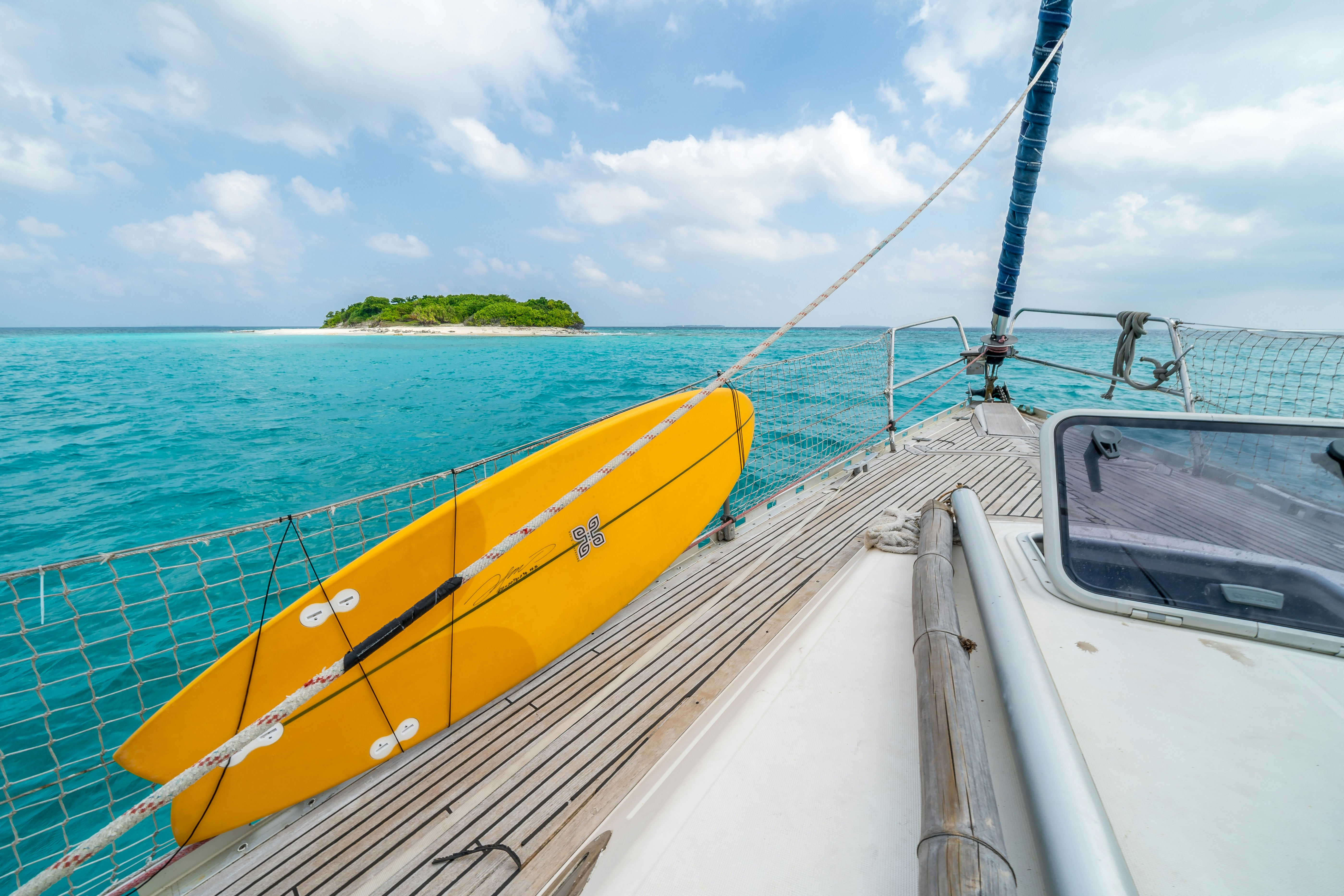 Yellow Surfboard Anchored on a Sloop Over Turquoise Waters