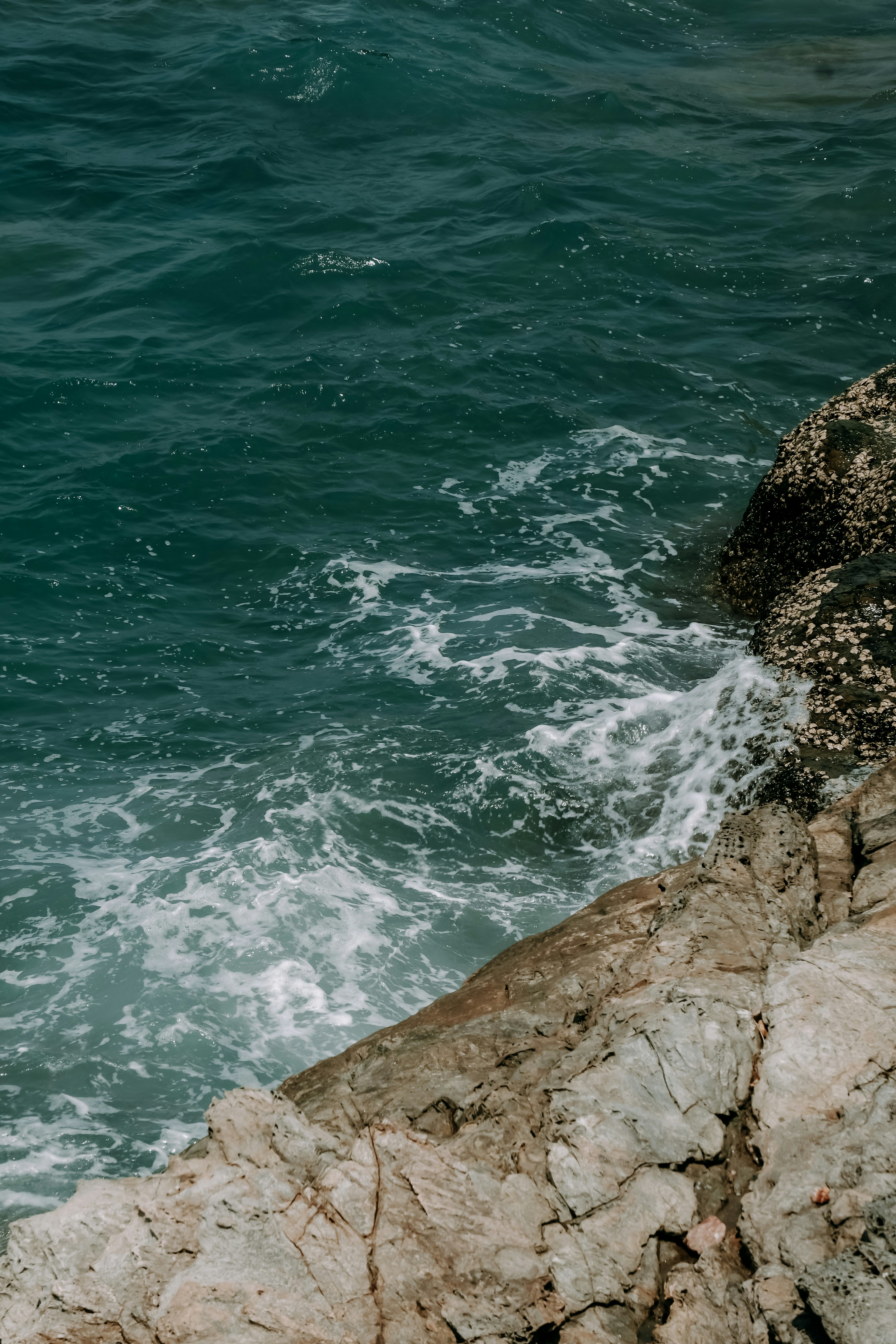 Rugged Shoreline: Craggy Rocks Meet Turquoise Sea