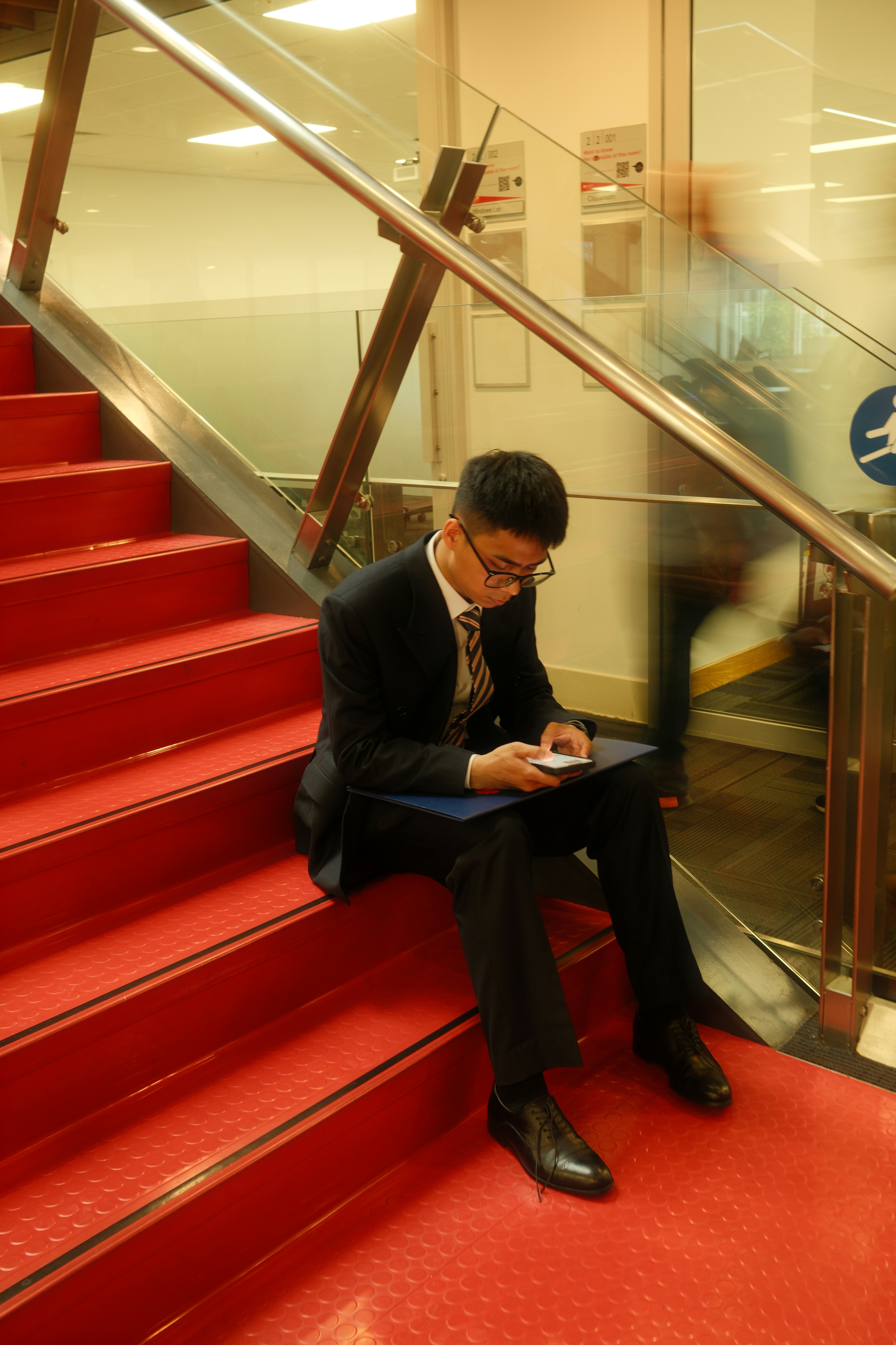 Businessman on Red Stairs: Focused on a Busy Moment
