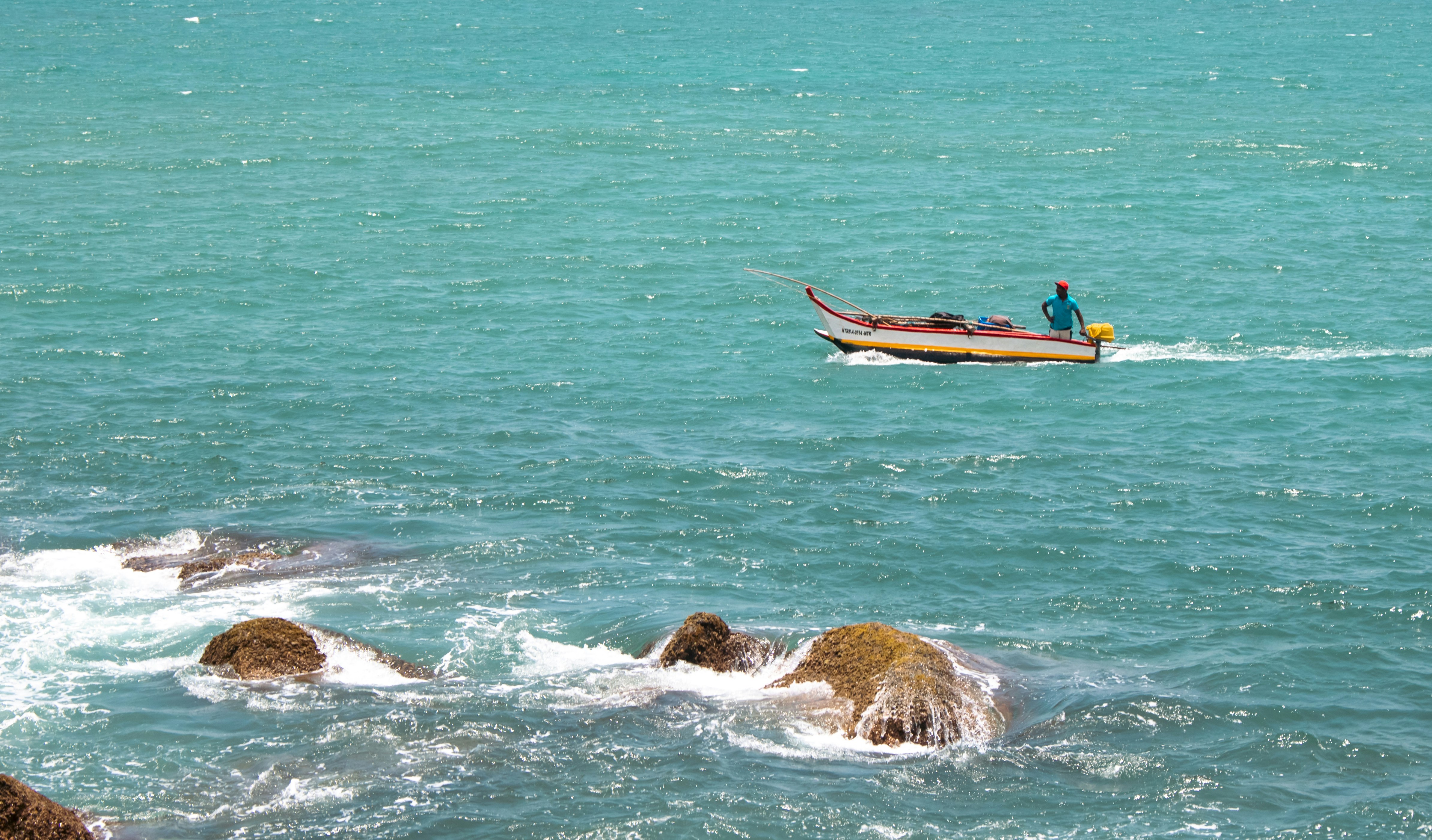 A lone motorboat courses the turquoise horizon