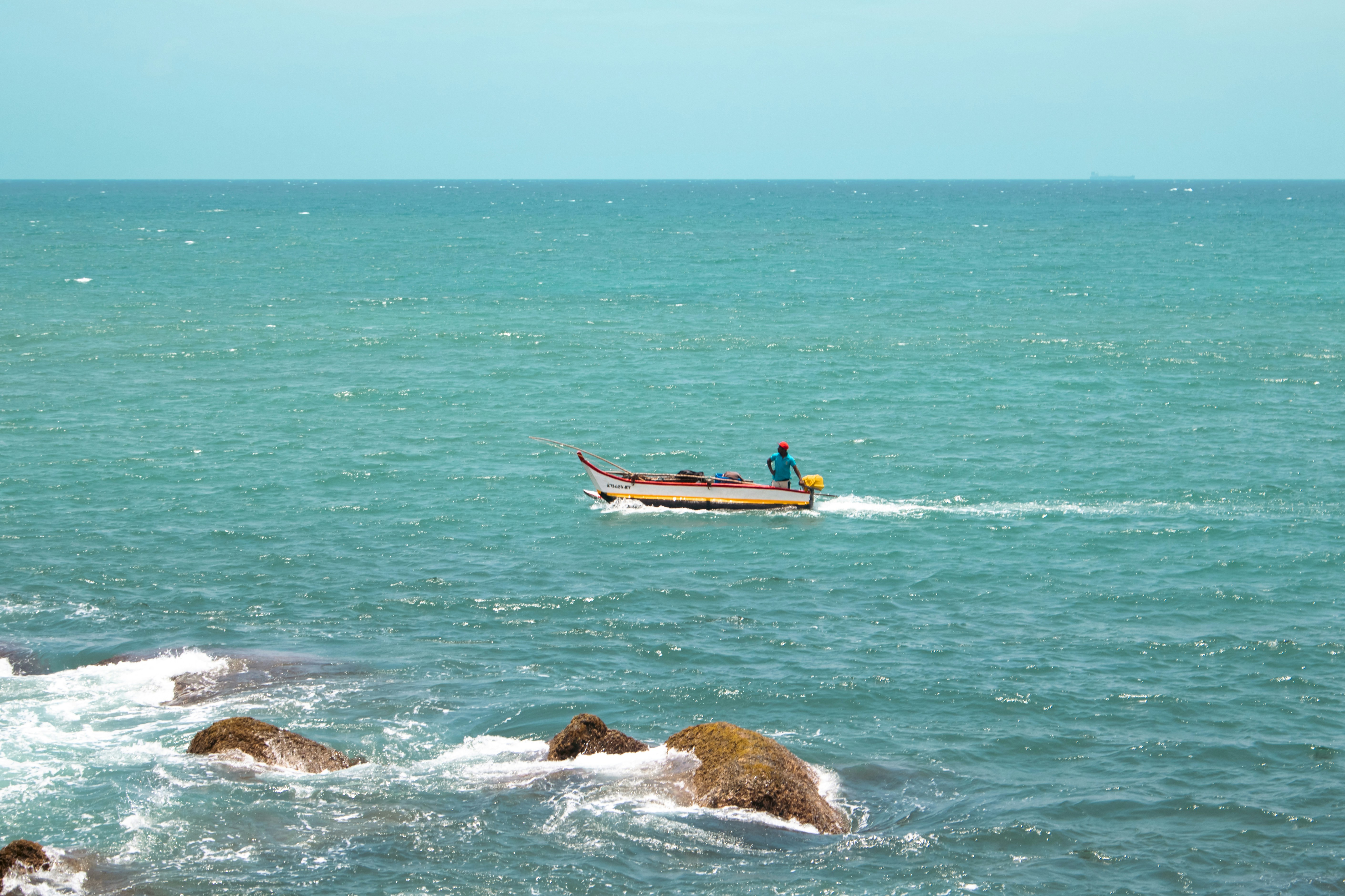 Boat on teal waters: lone motorcraft skims toward the horizon