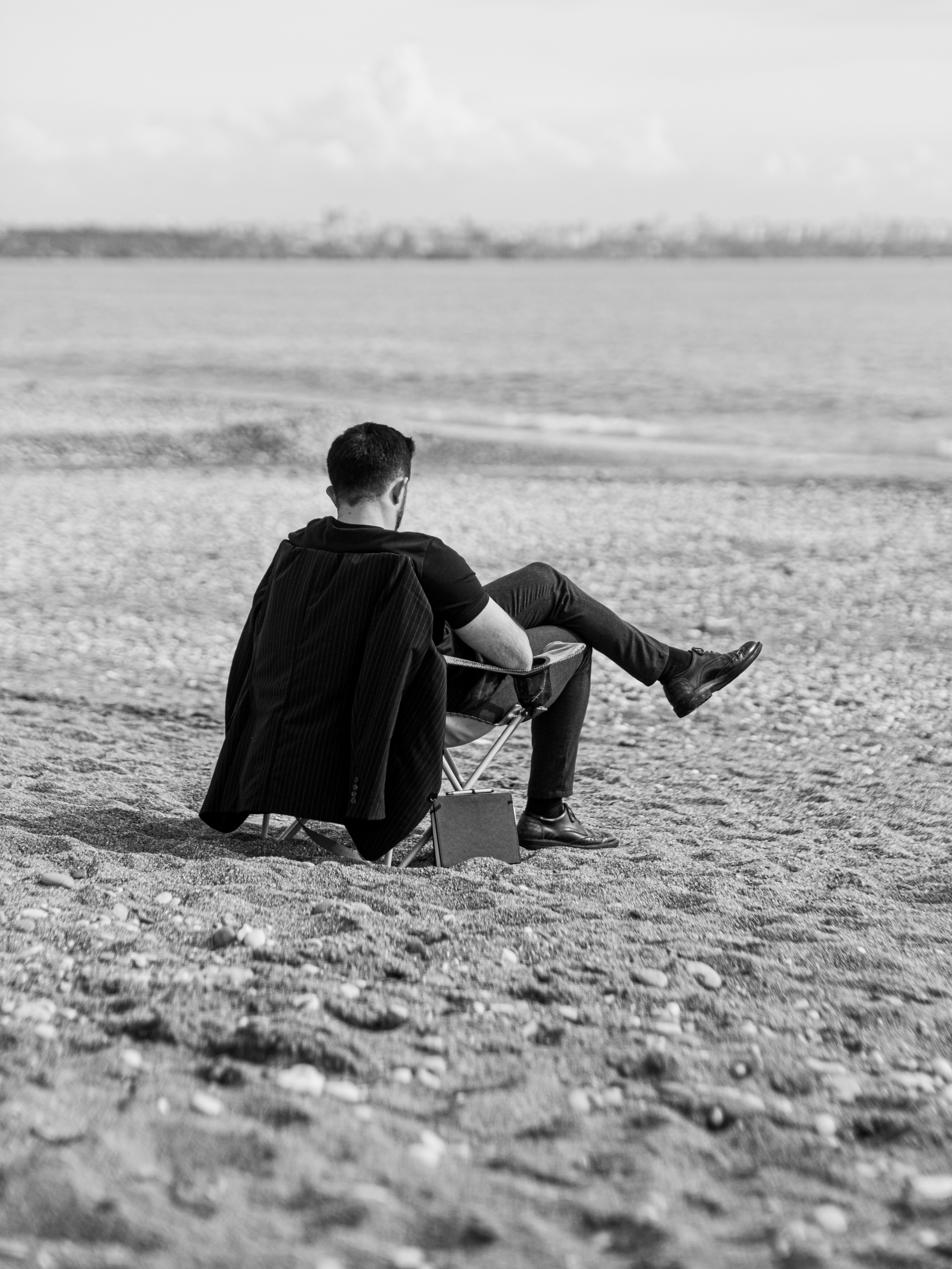 Solitary on the Shore: Quiet Portrait of a Reader in Black and White