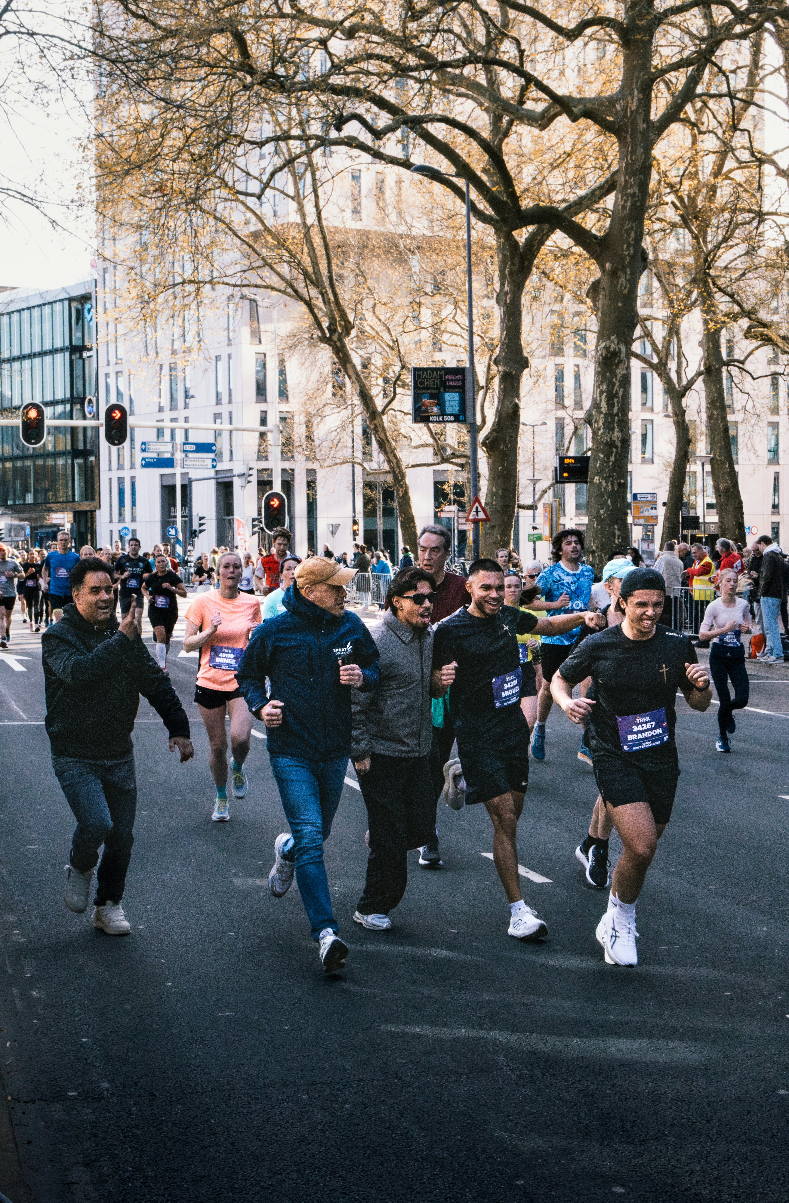 Runners Converge on City Route as Autumn Trees Crown the Street