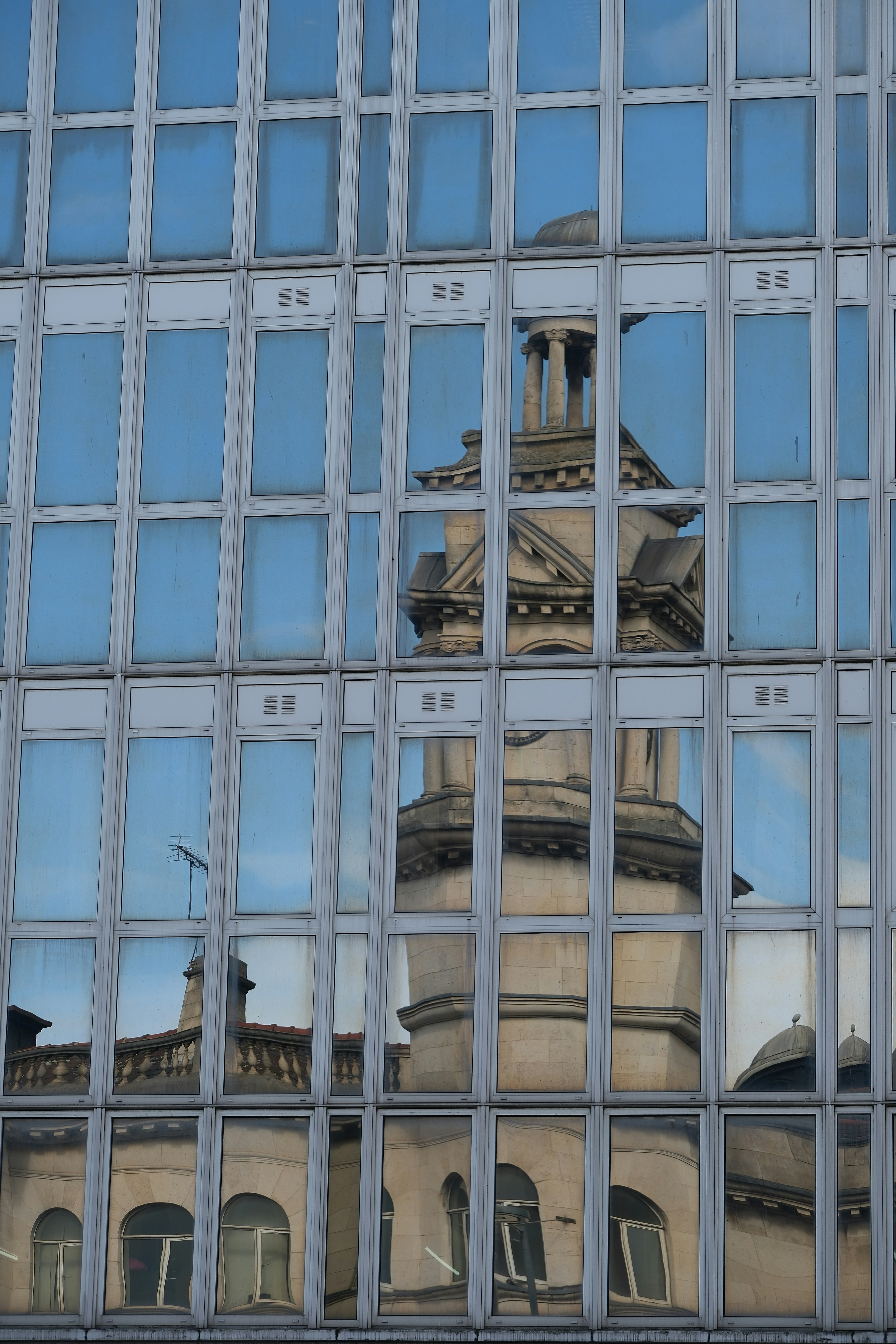 Reflected History: The Old Clock Tower in a Glass Curtain
