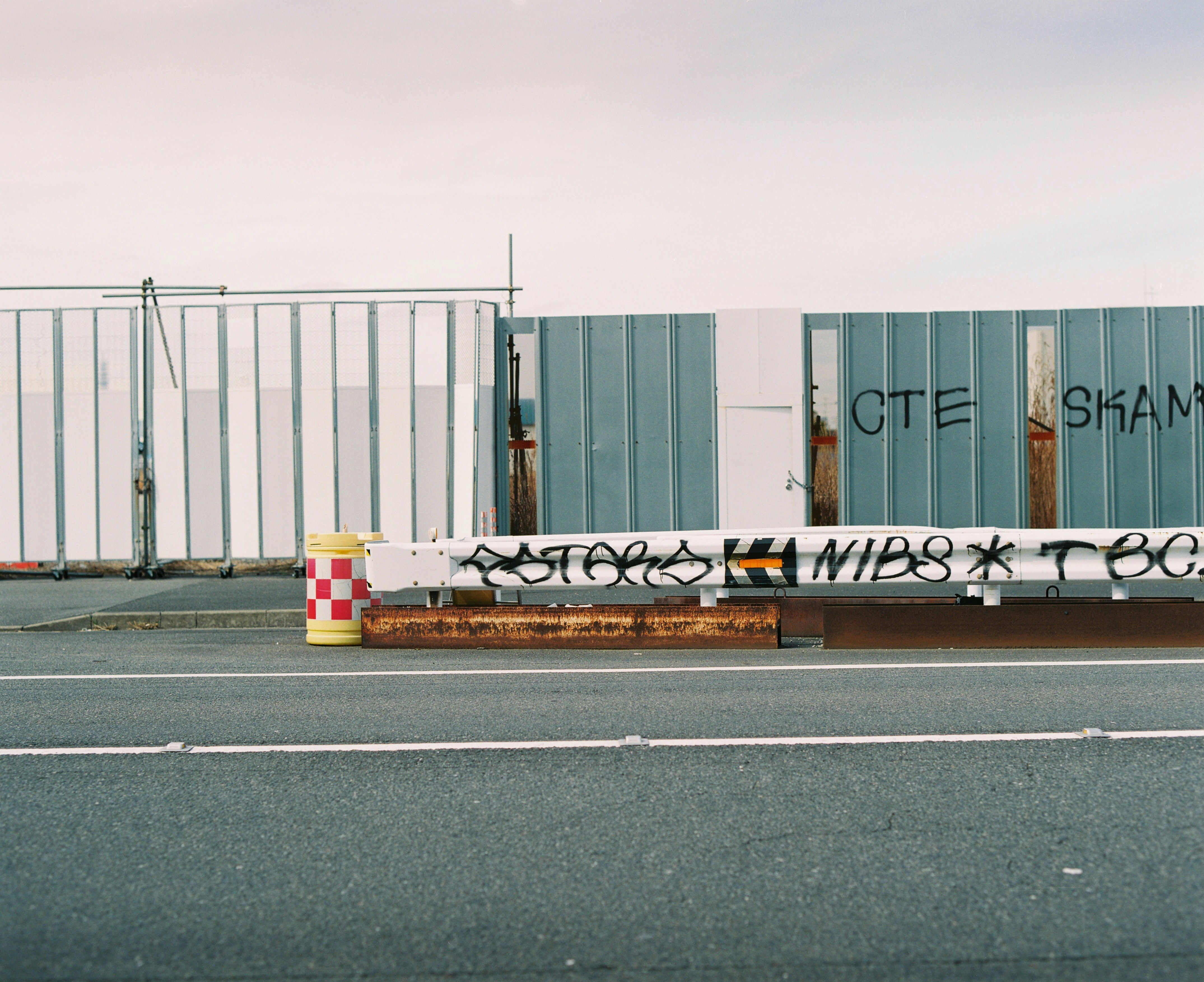 Barrier and Graffiti Across the Industrial Foreground