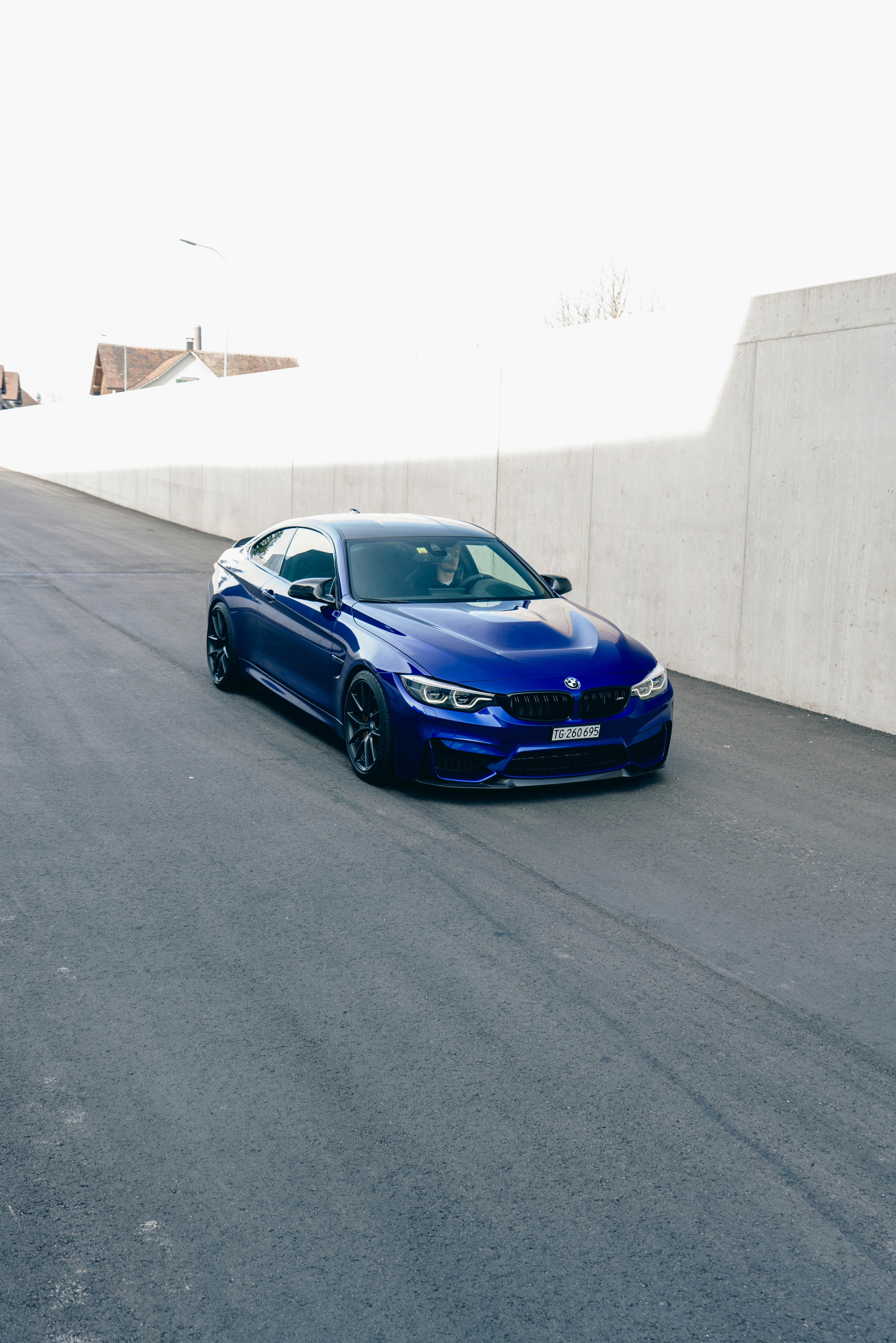 Blue BMW Streaking Down a Concrete Wall Alley