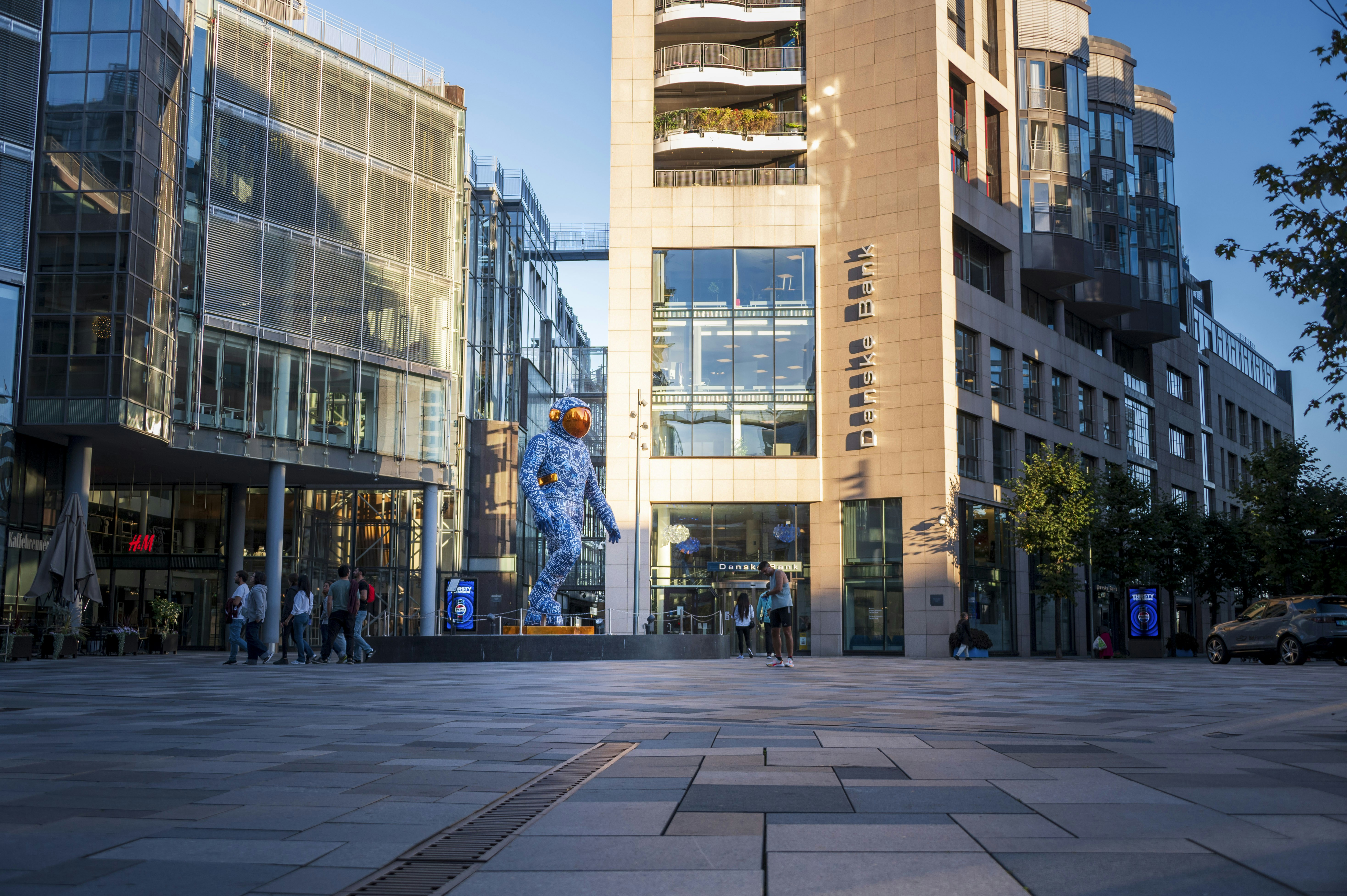 Urban Plaza with Sculpted Figure Framed by Modern Glass and Brick