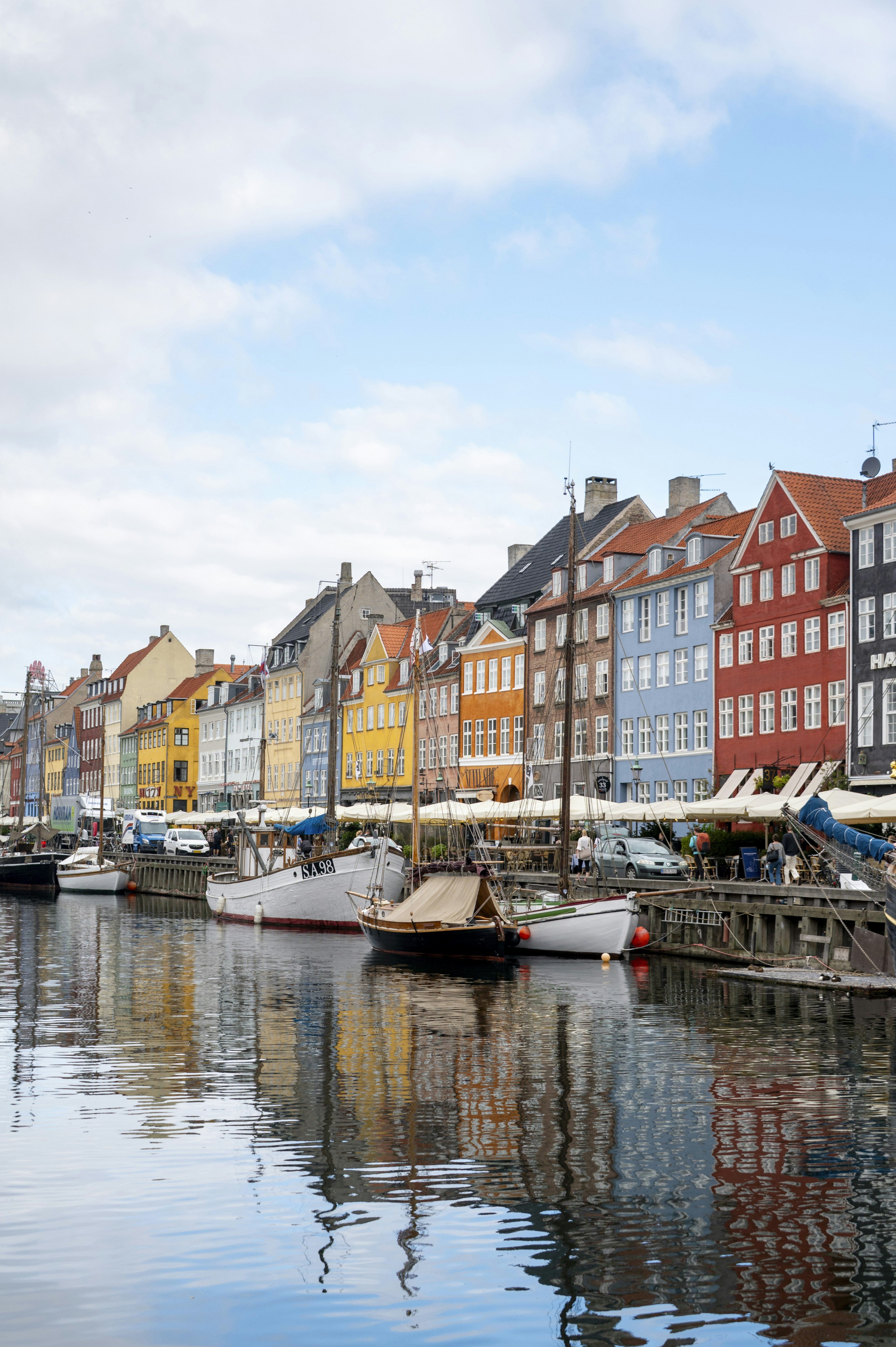 Colorful Waterfront Row: Boats and Bright Houses Reflect on Calm Danish-Style Canal