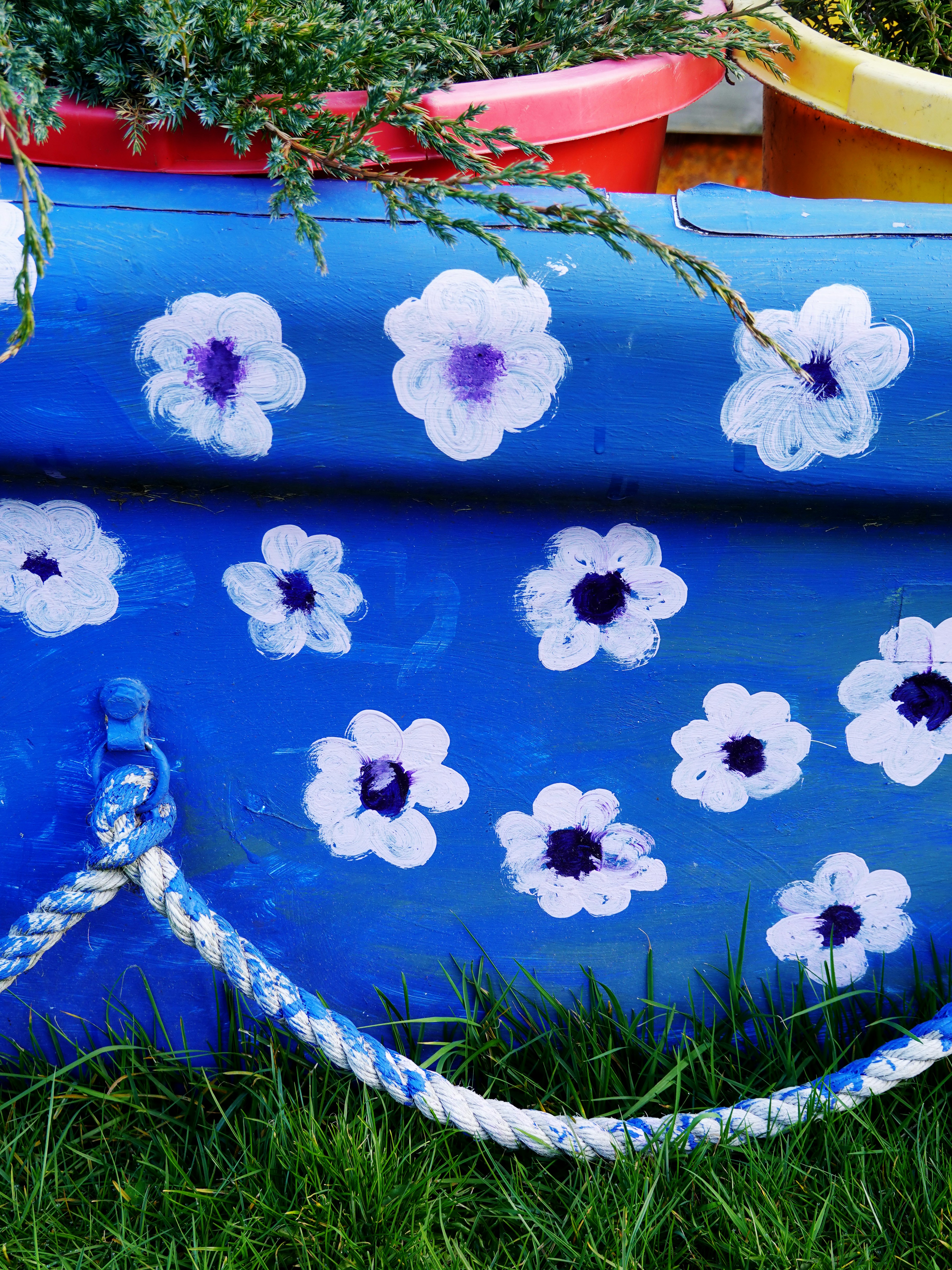 Blue Barrel Blooms: Painted Petals and Rope in the Garden