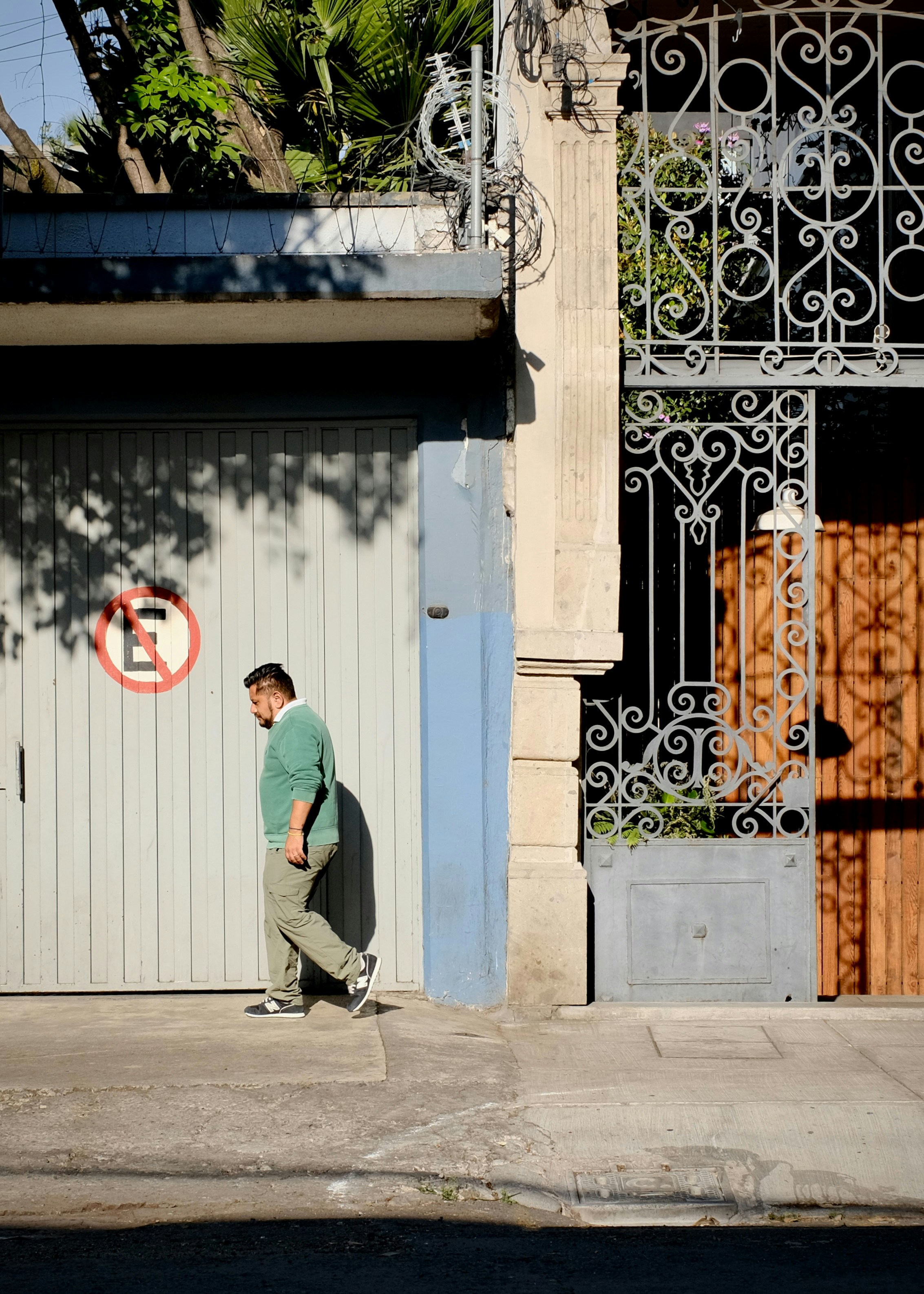 Green-sleeved pedestrian crossing a quiet urban gateway
