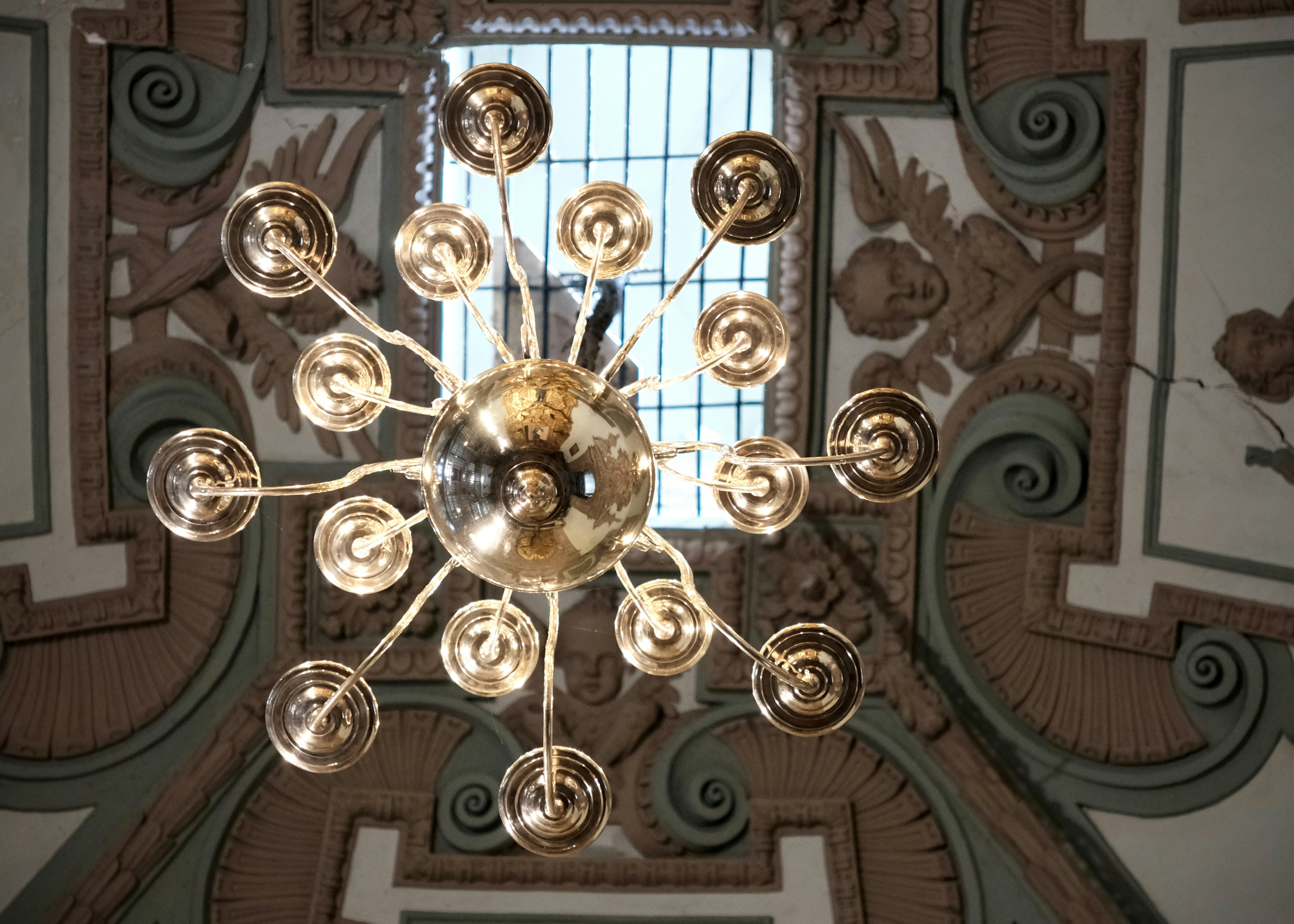 Ornate Orbital Chandelier Suspended Above an Elaborate Ceiling