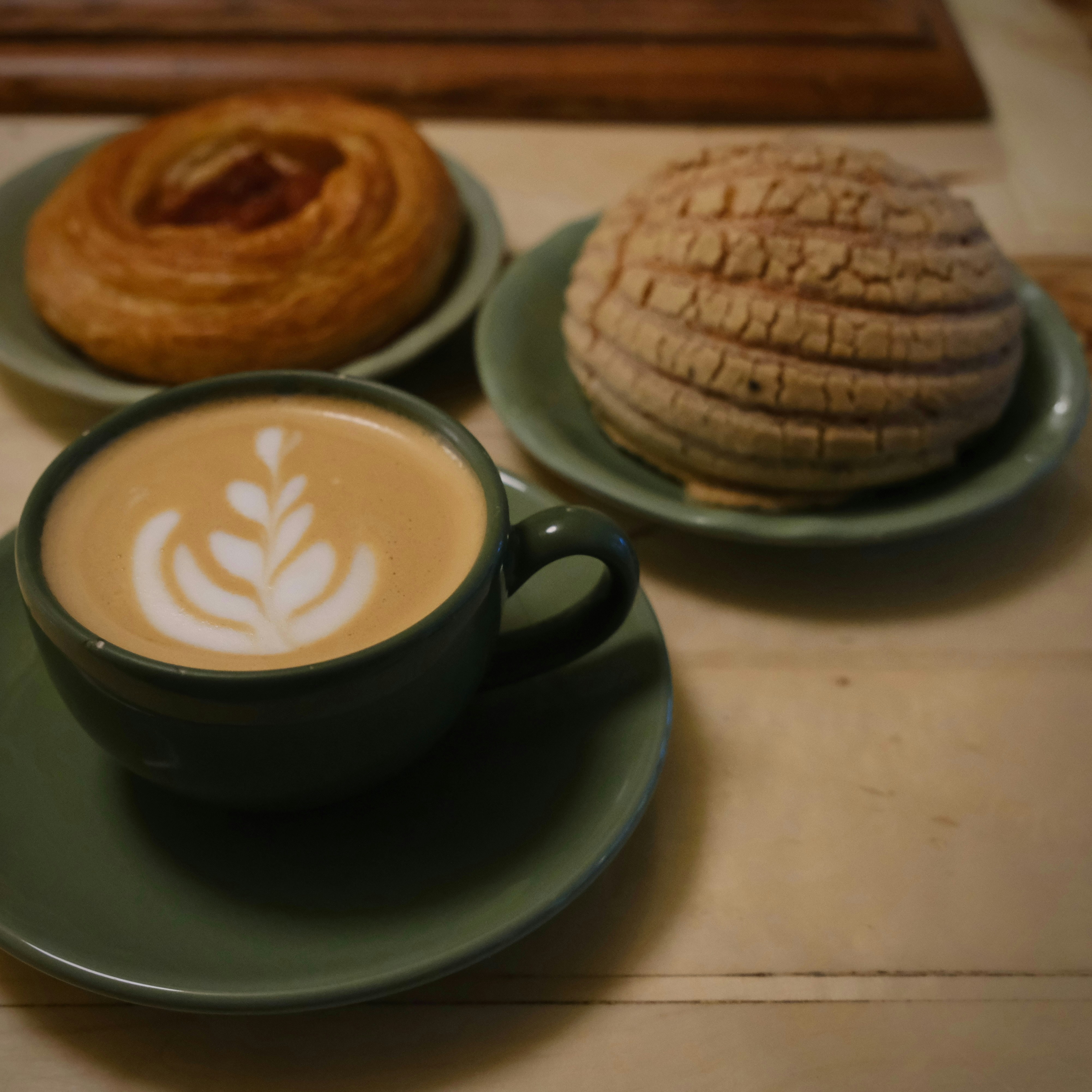 Latte Art Centered Between Pastry and Cup