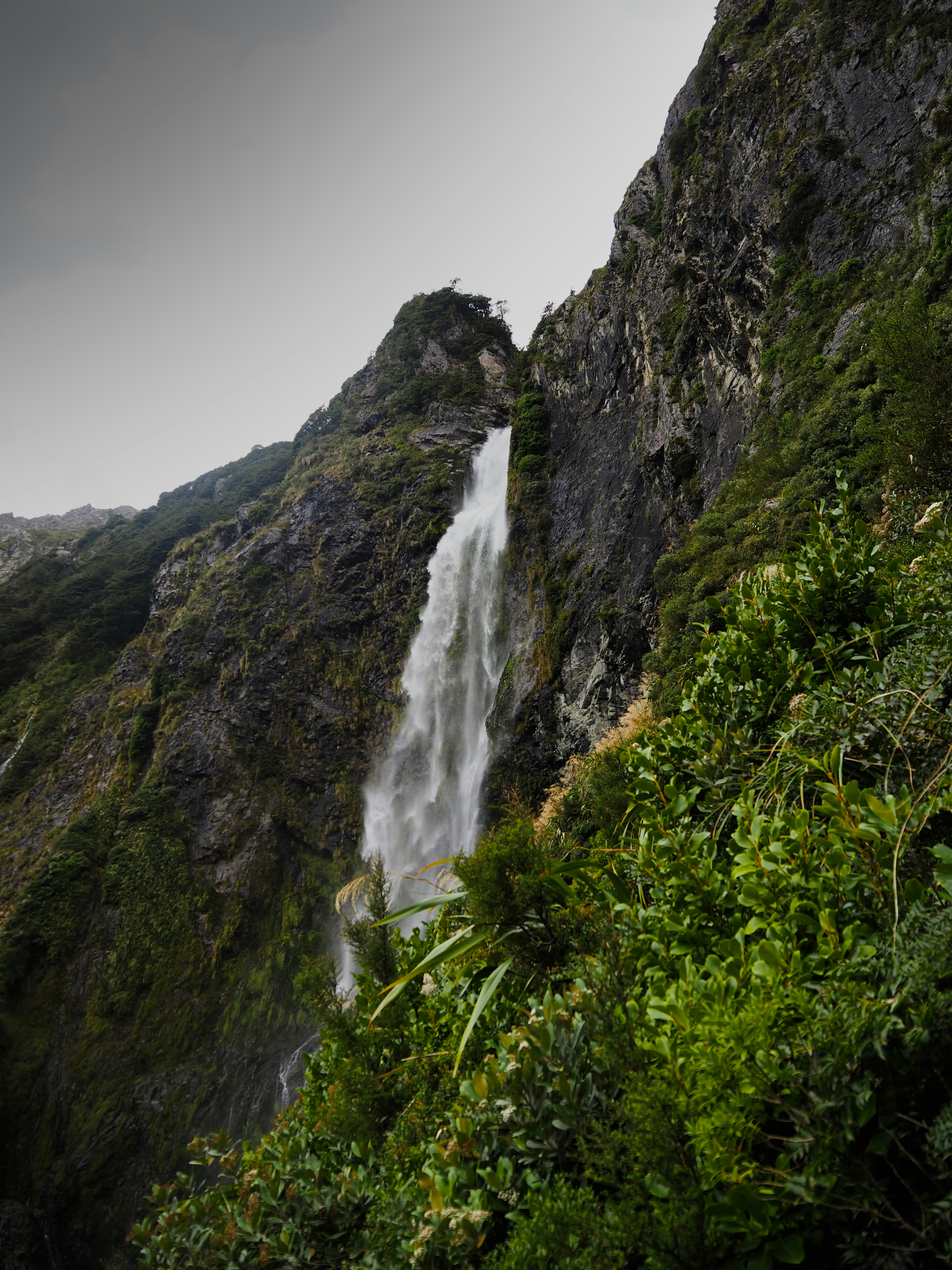 A Ribbon of Mist Cascades Between Steep Cliffs