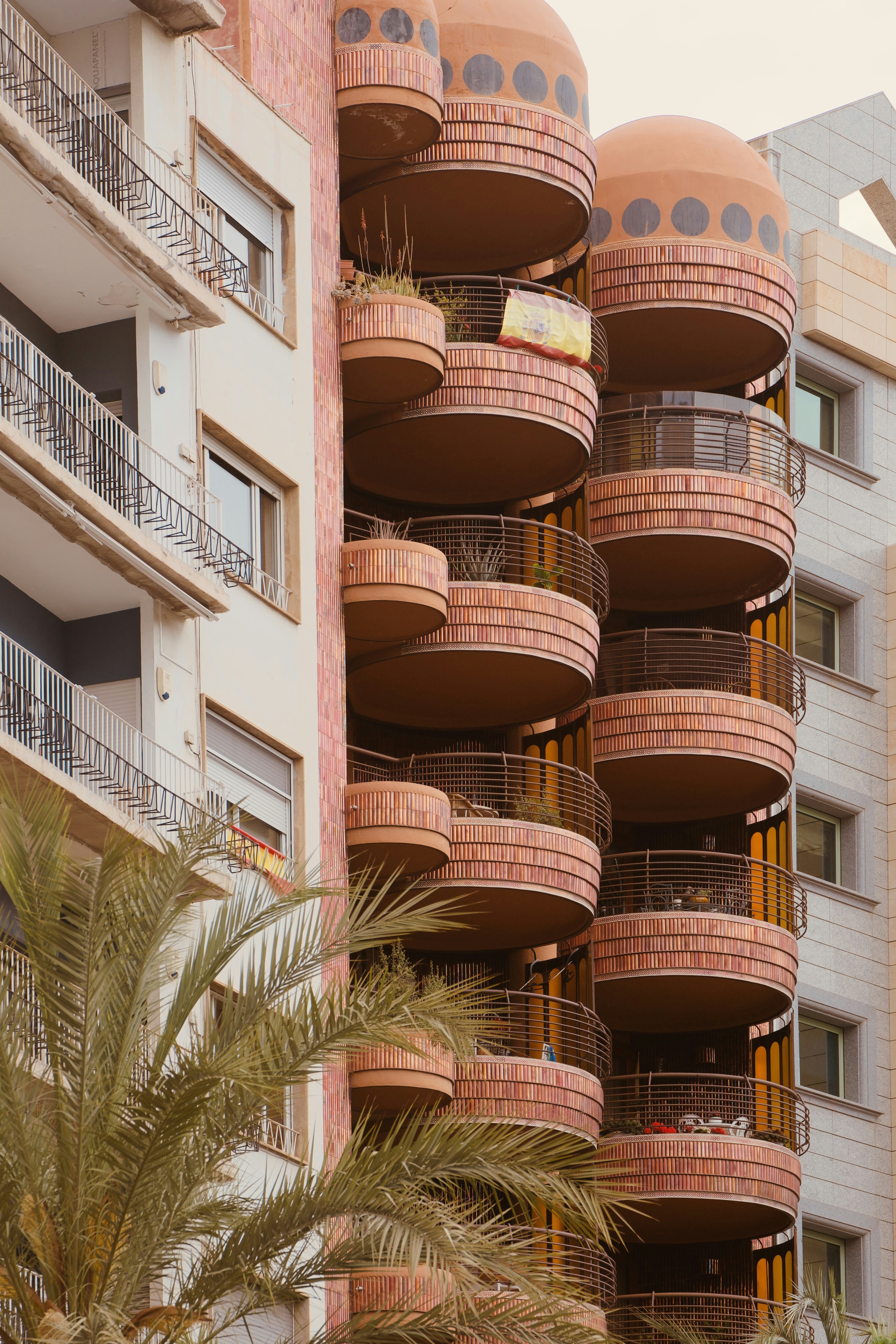 Curved Terracotta Orbits: balconies spiraling up a sunlit high-rise
