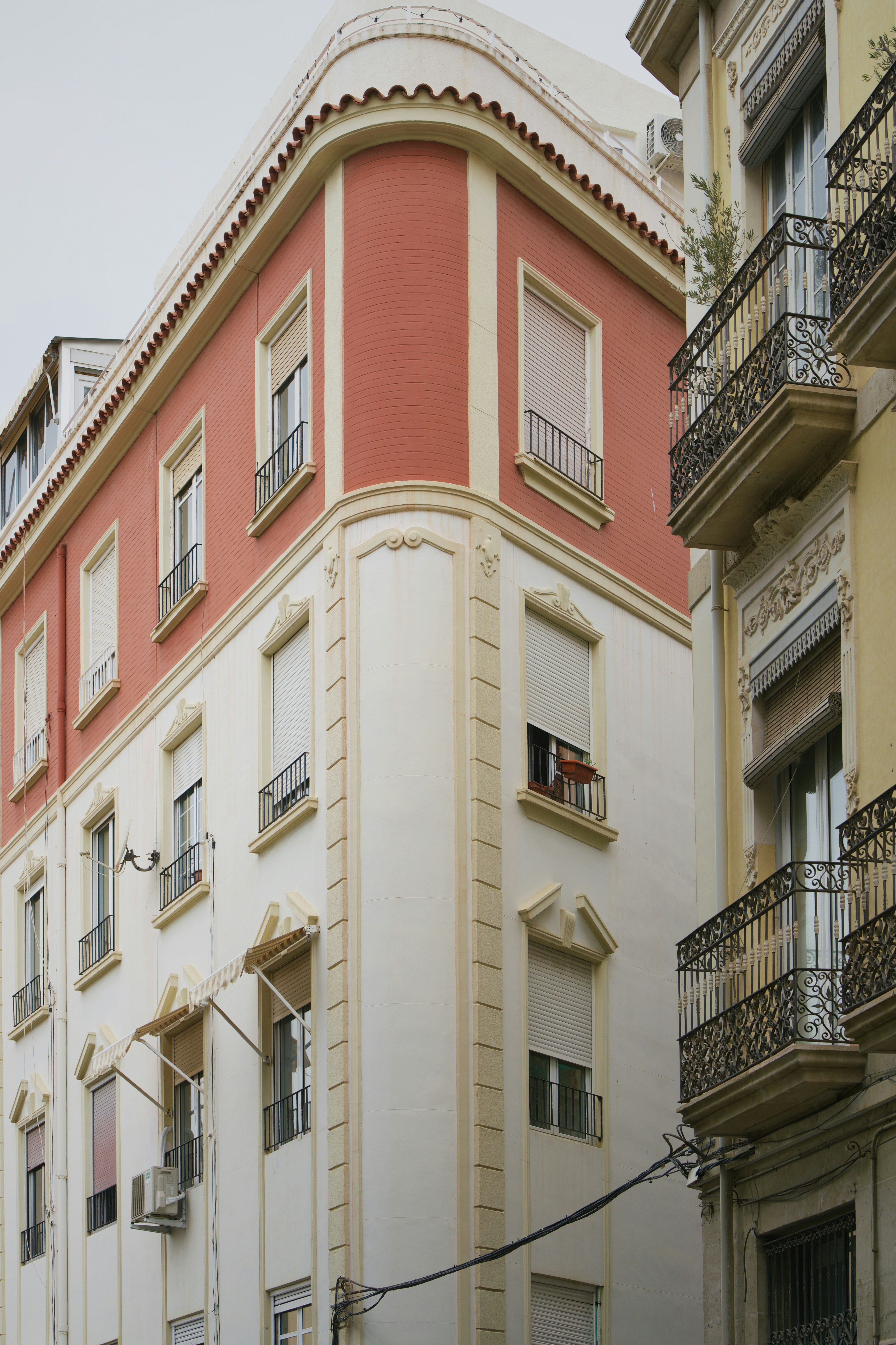 Corner of Castilian Red: A Mediterranean Facade Rising with Quiet Details