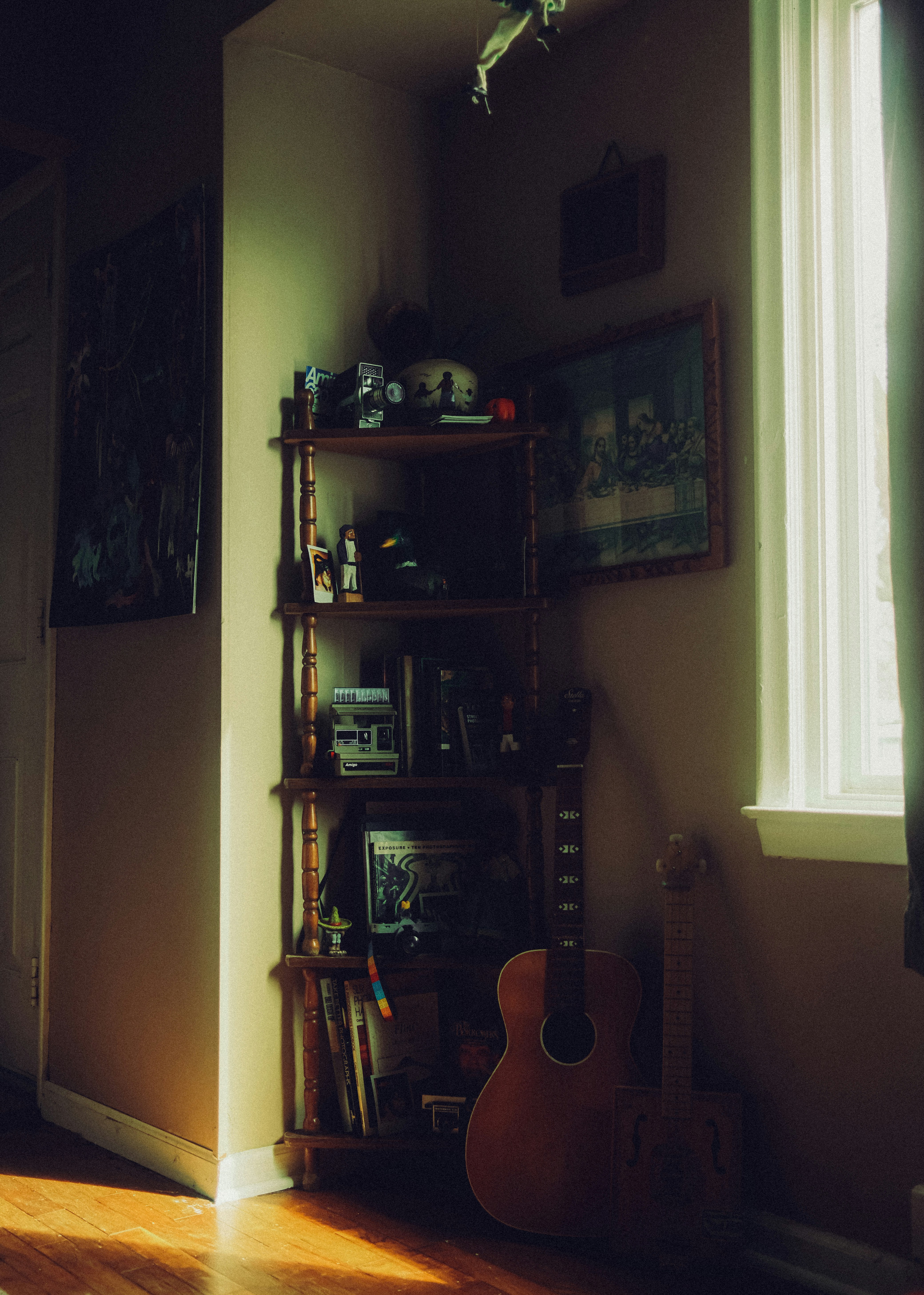 Sunlit Corner Studio: Acoustic Guitar Resting beside a Bookshelf