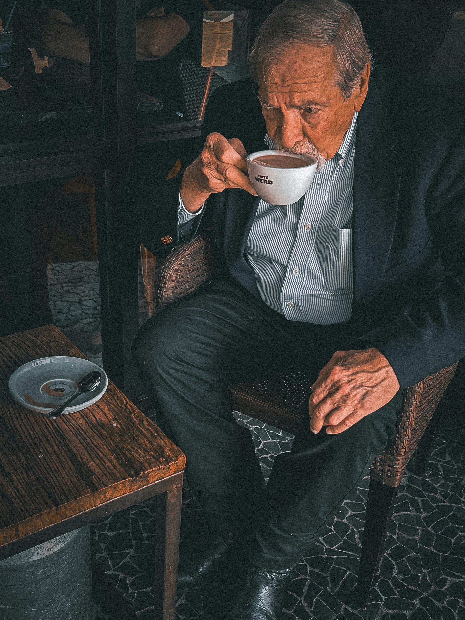 Quiet Café Ritual: Elderly Gentleman Sips Espresso