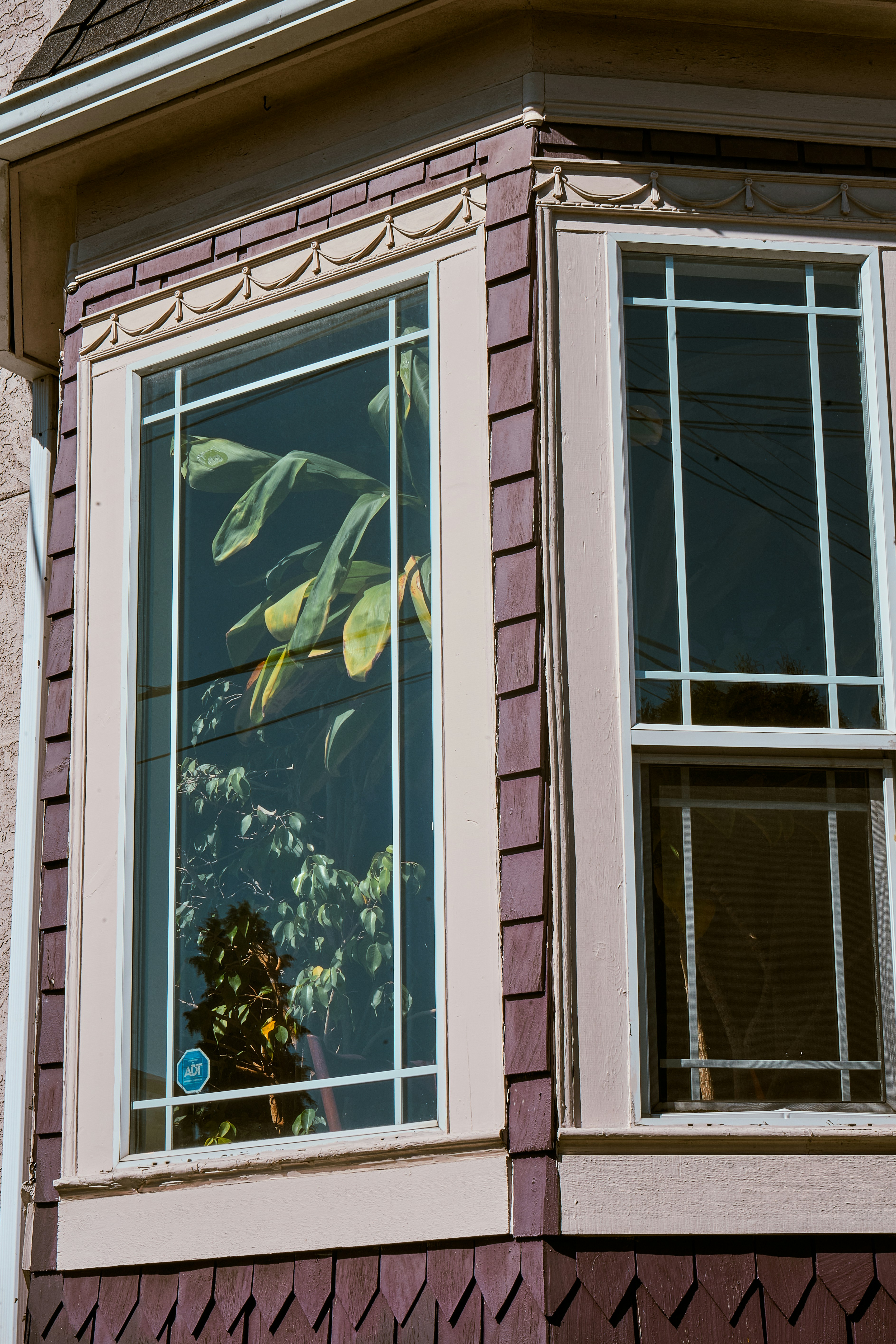 Sunlit Victorian Window Corners: A Close-Up of a House Facade