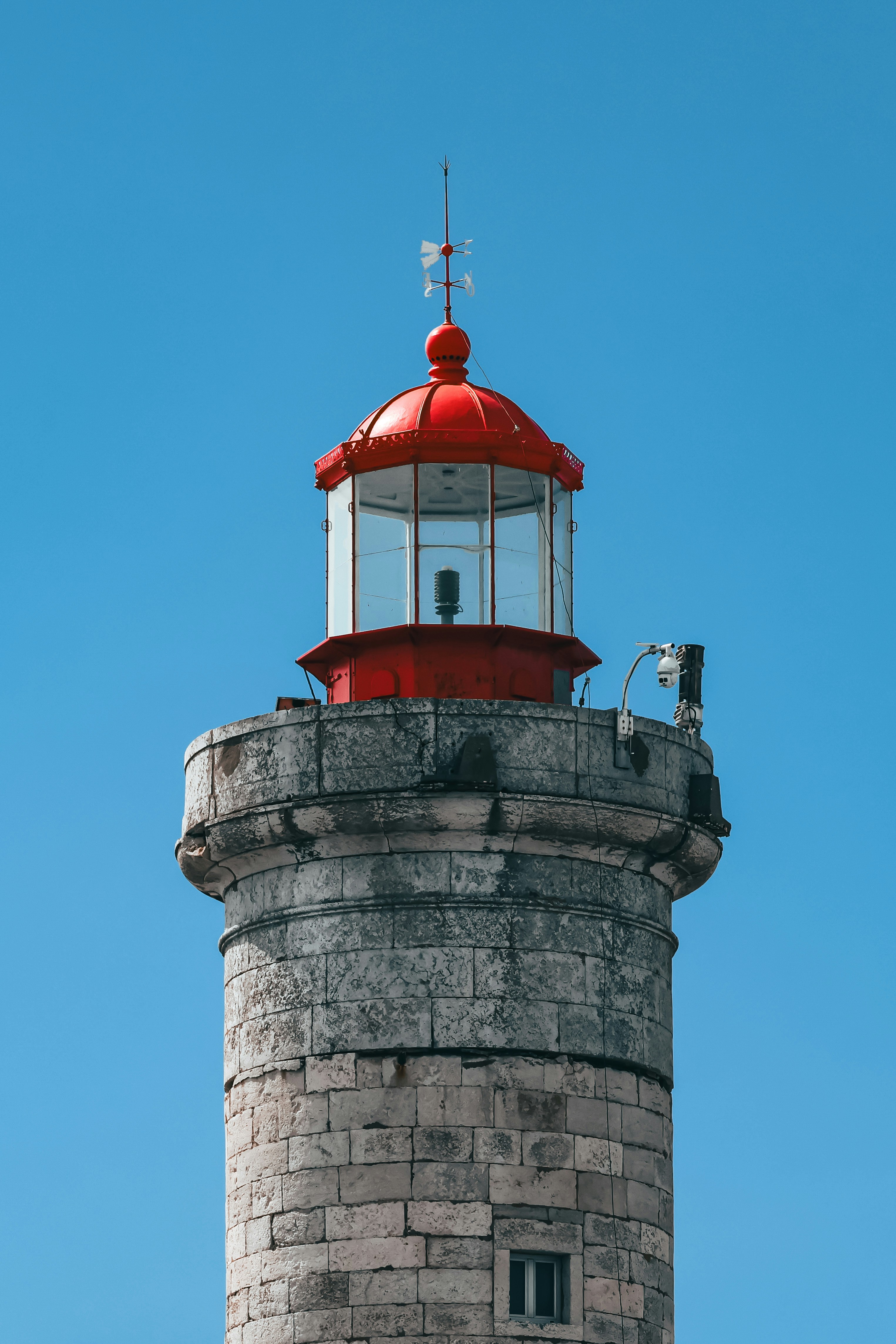 Red Beacon on Stone Crown: A Luminous Lighthouse Tower Reaching Toward a Clear Sky