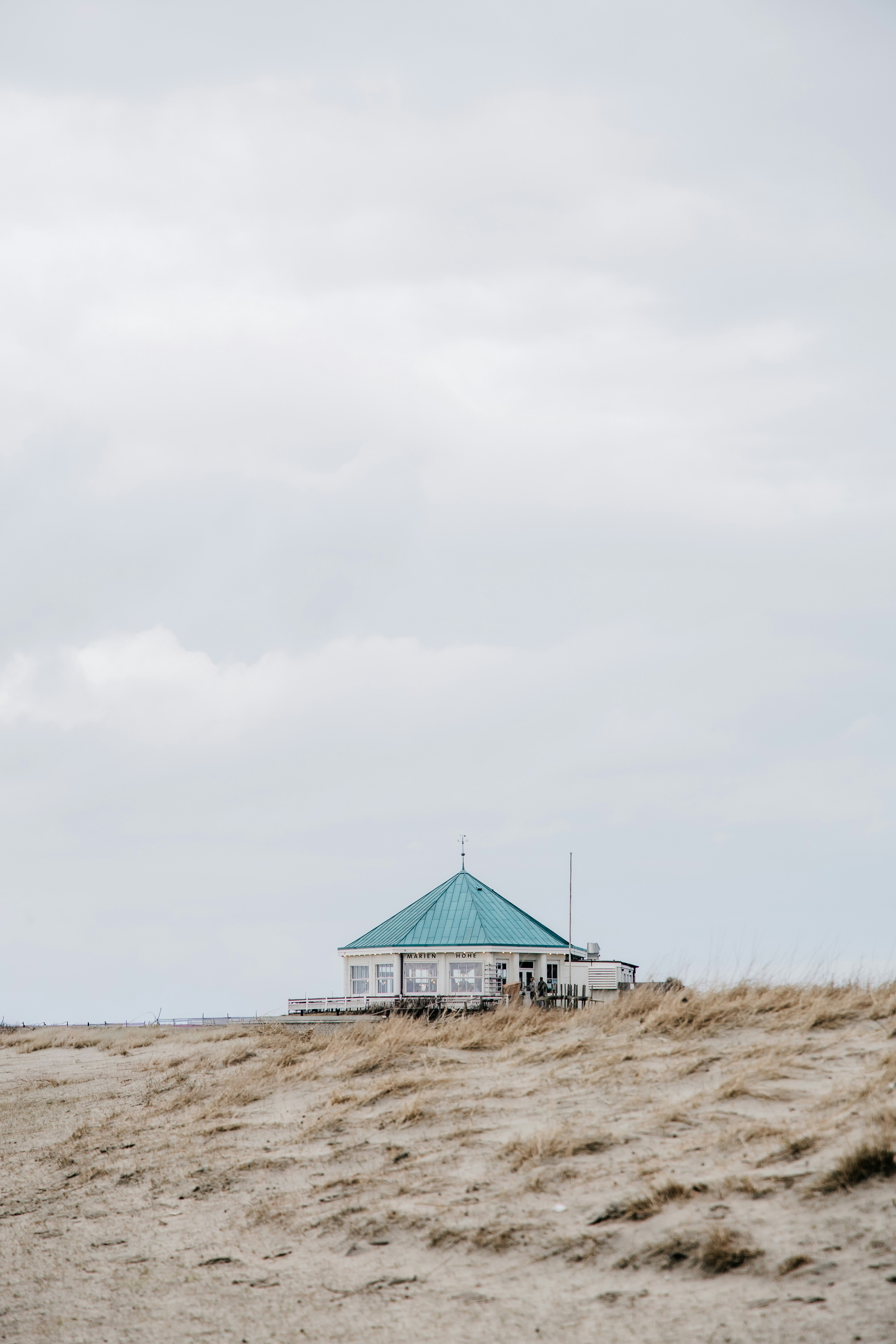 Coastal Pavilion at the Edge: A Quiet Beach Hut with Turquoise Roof