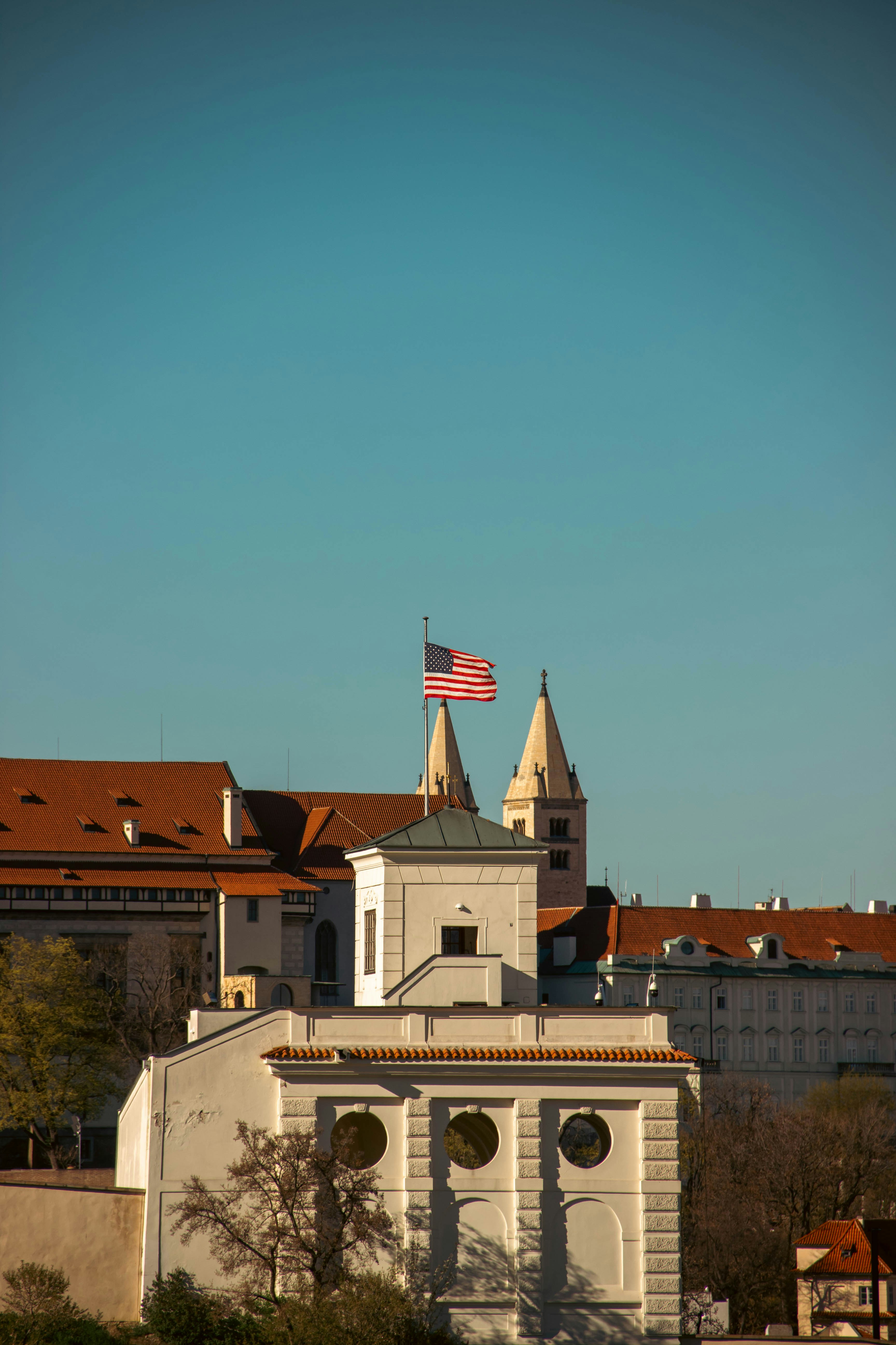 Flag Over the Torre Houses: A Quiet City Silhouette Beneath a Cerulean Sky