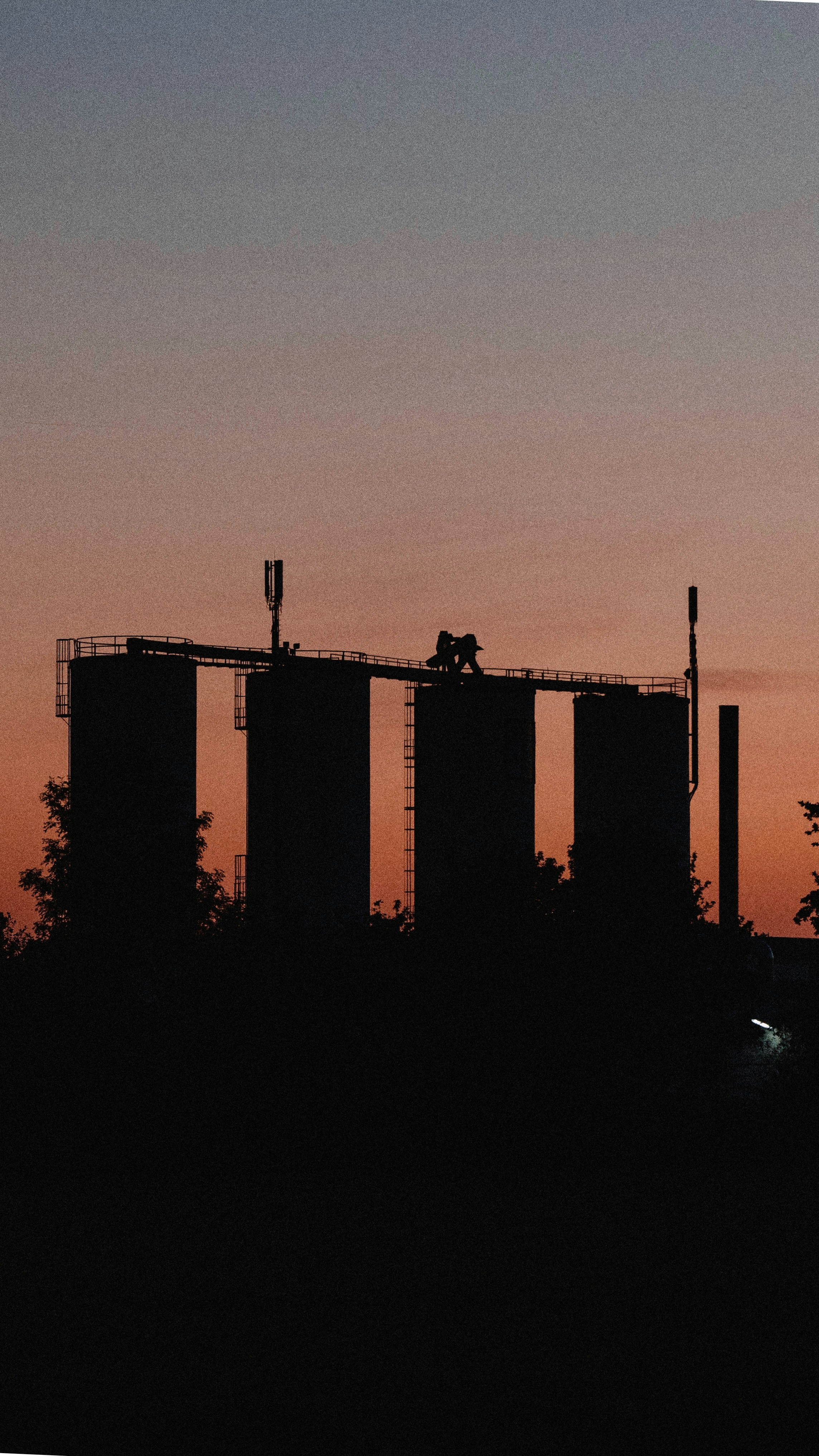 Silhouette at Dusk: Silos Against a Burning Horizon