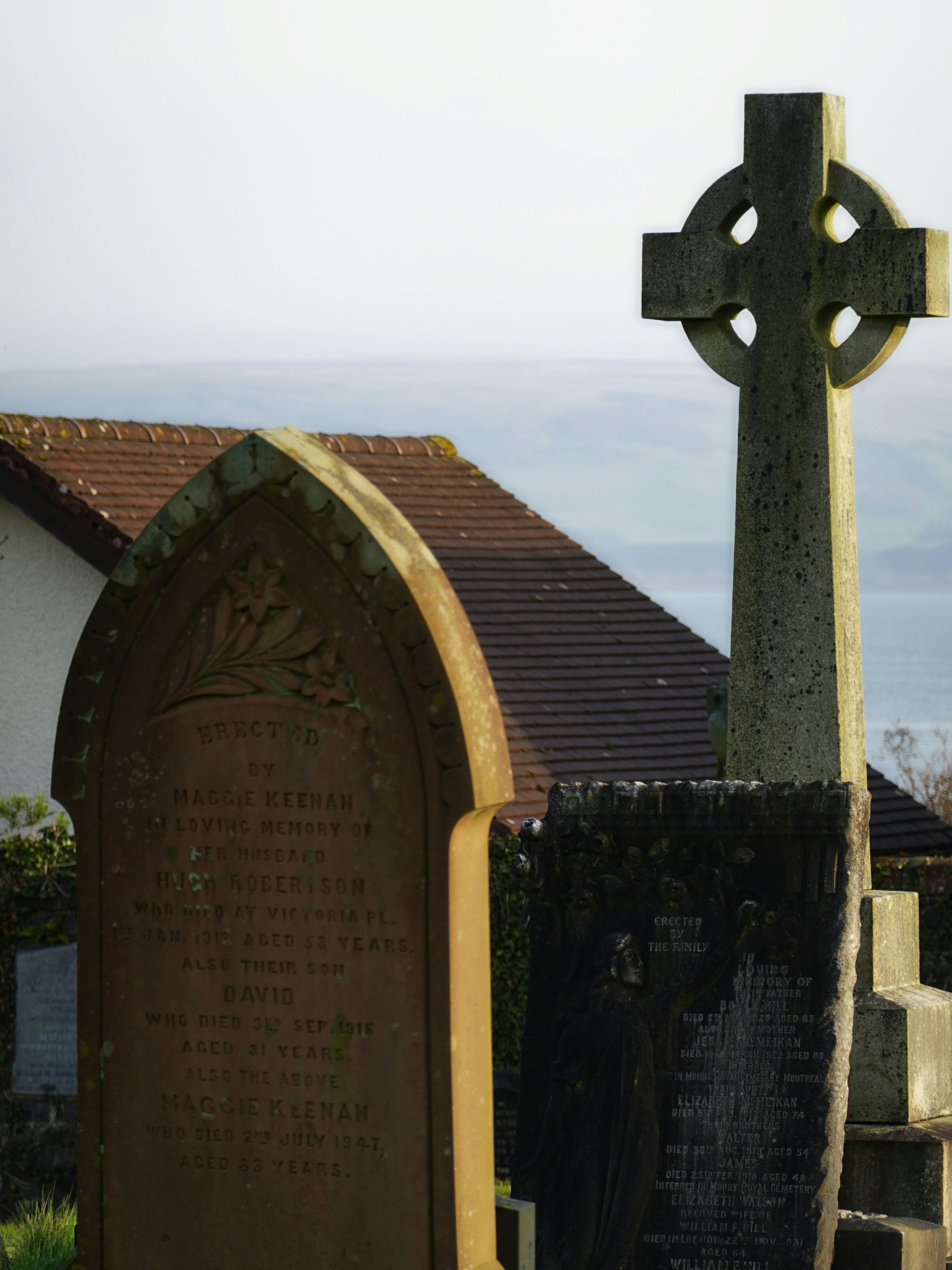 Cross and Memorials: Weathered Stones Against a Coastal Backdrop
