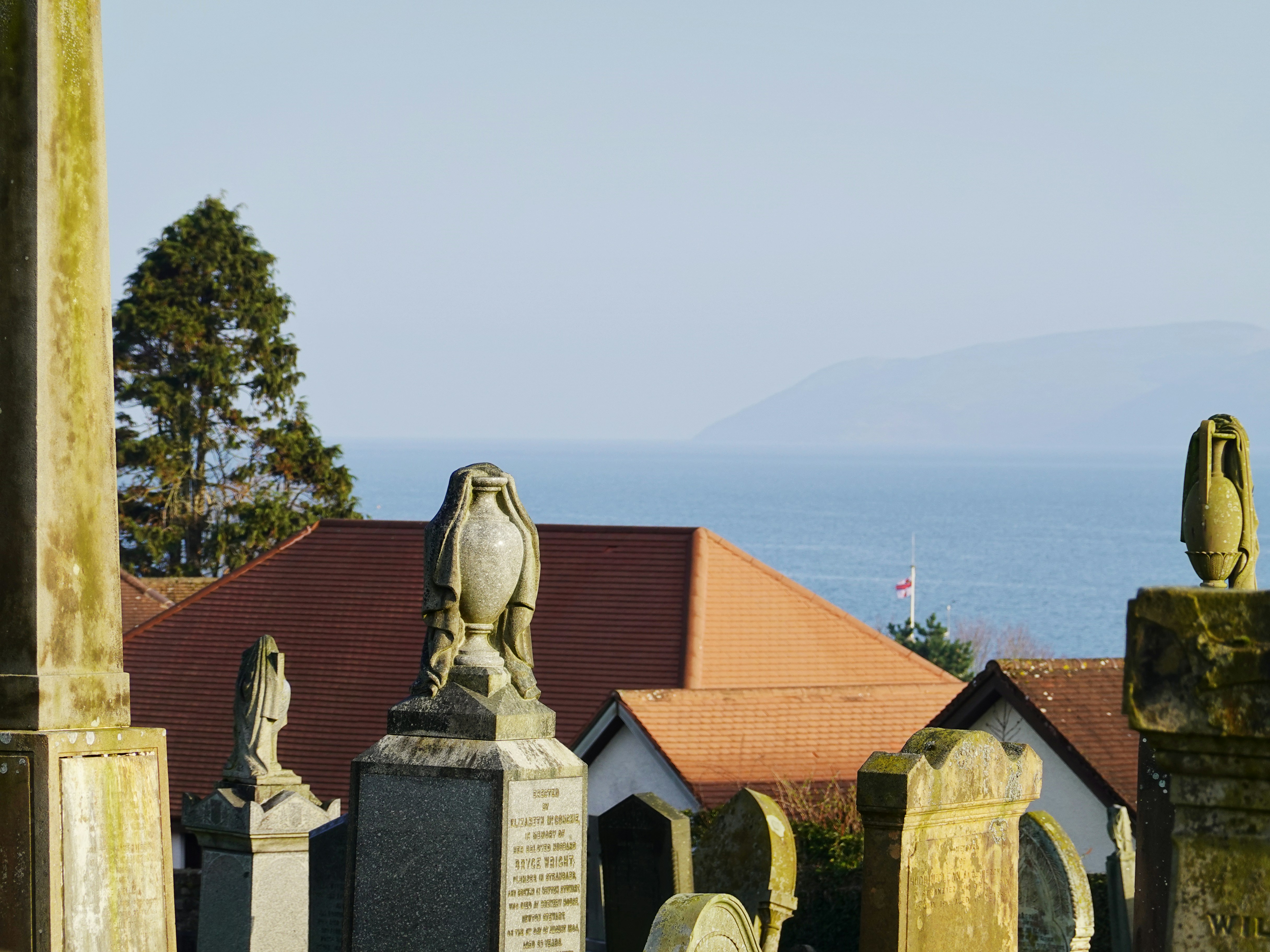 Statues over a tiled village with sea horizon
