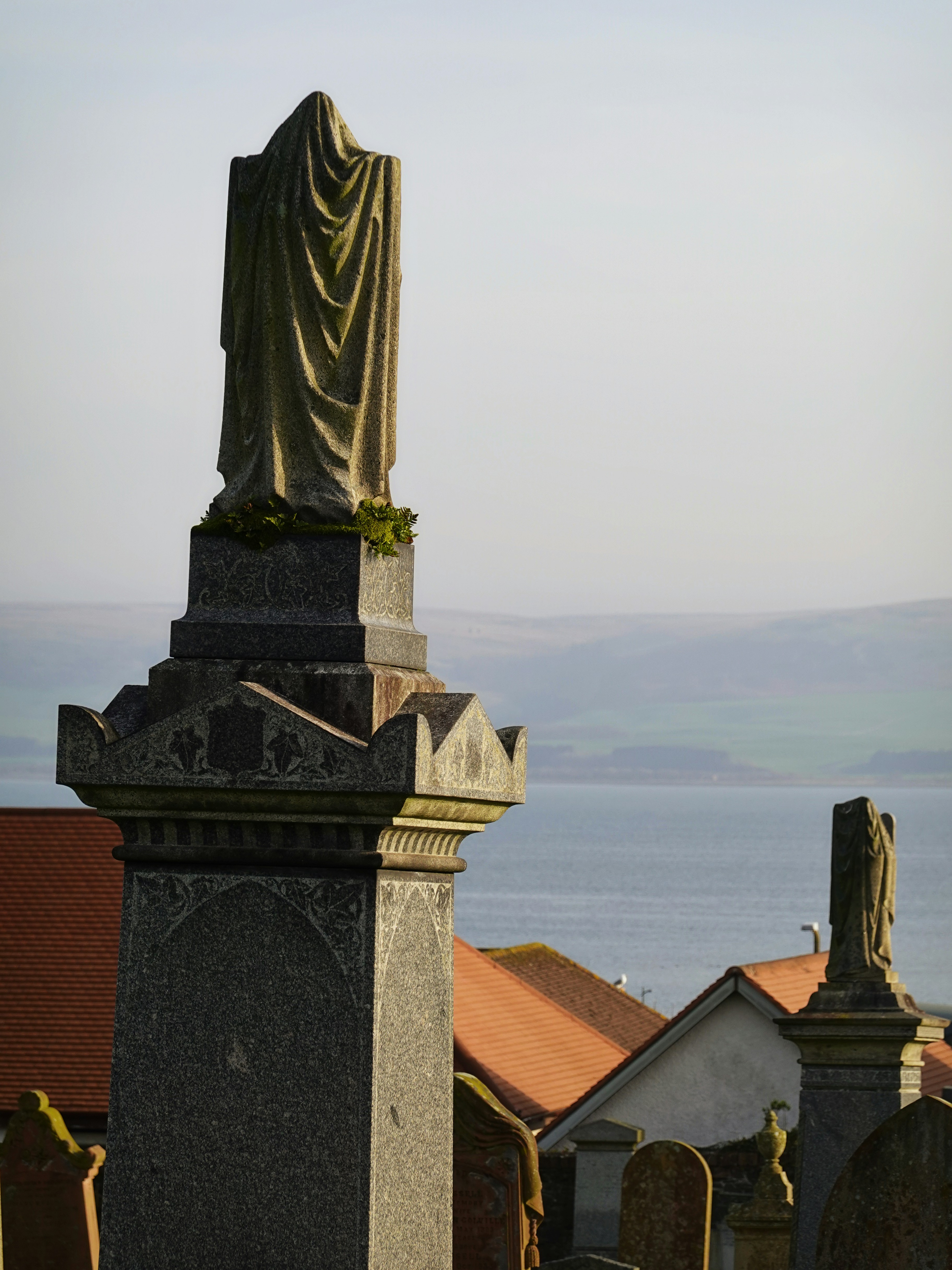 Quiet Sentinel: A Weathered Statue Overlooking the Sea