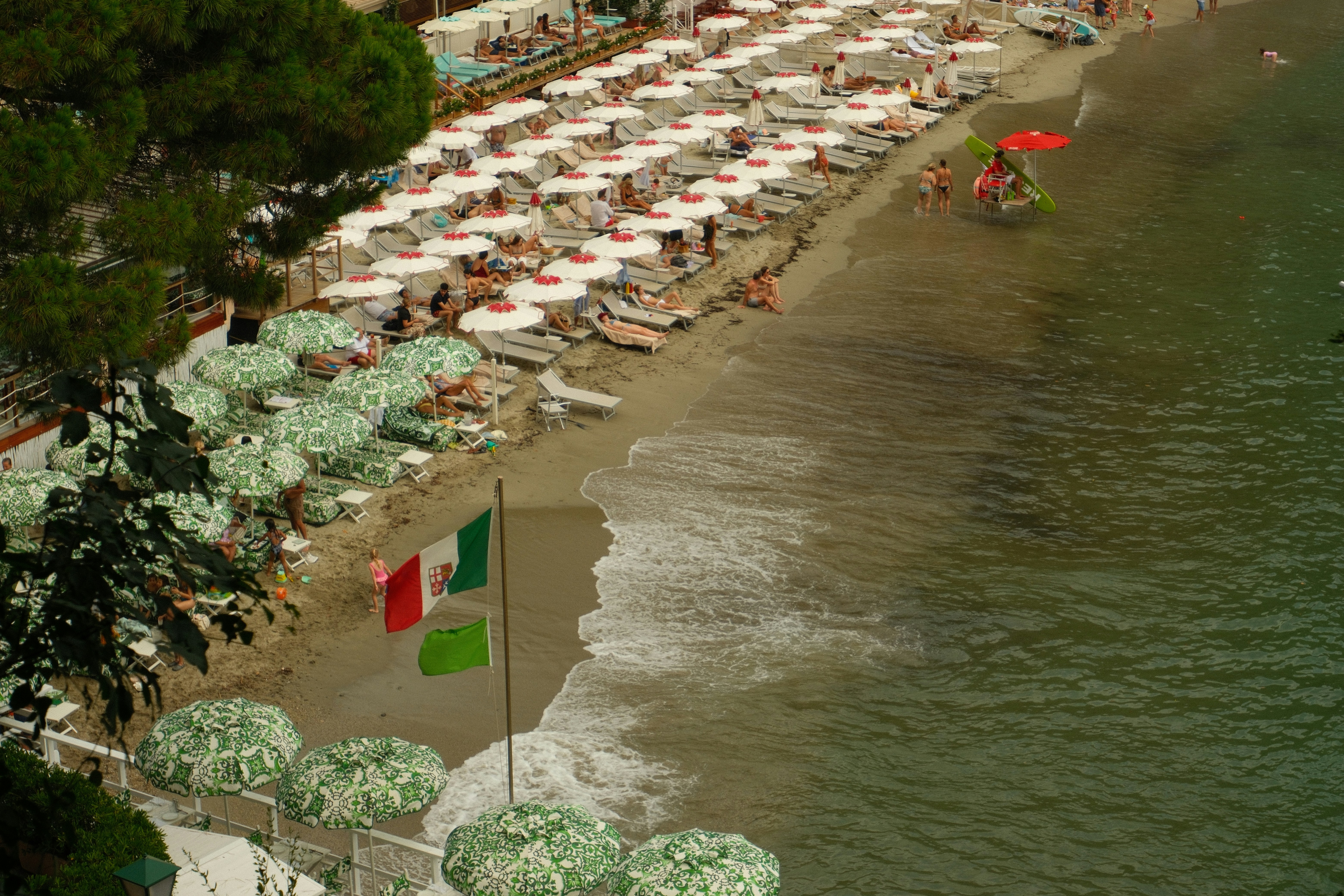 Sunlit Beachfront Corridor of Umbrellas and Green Umbrella Fringes