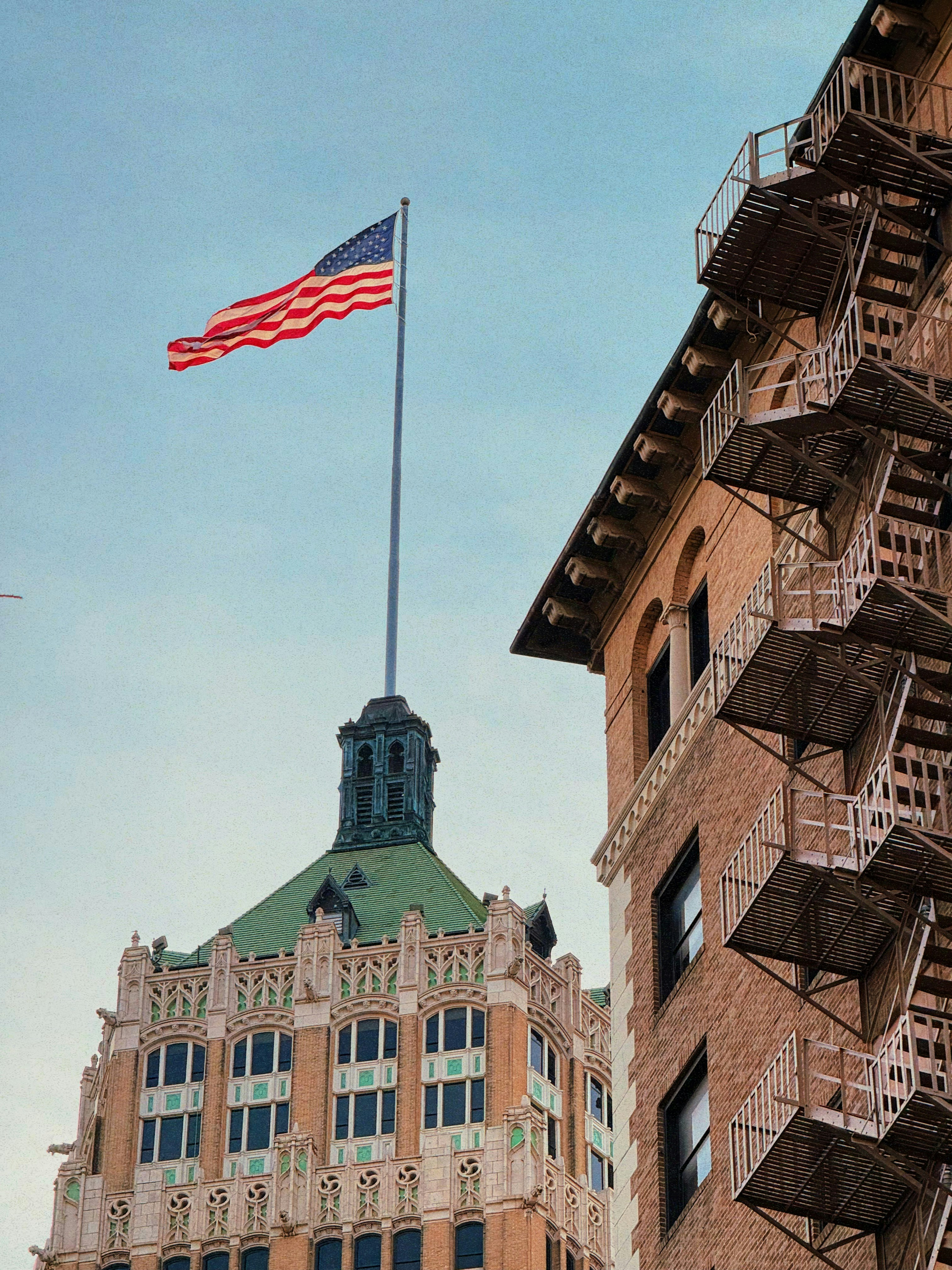 Flag and architectural elegance: urban towers under a clear sky